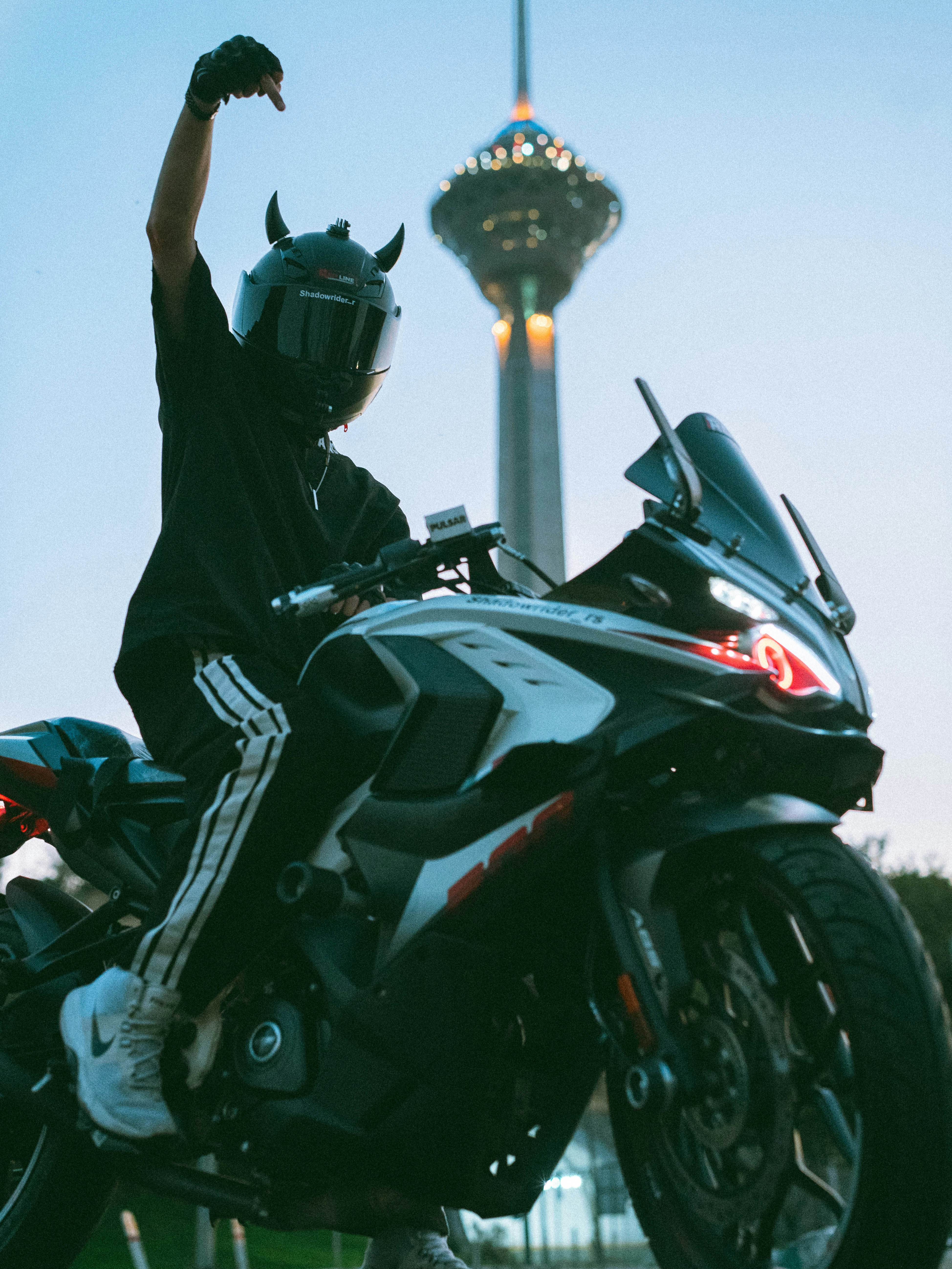 Moonlit Rider: Helmeted Confidence Beside the Neon Skyline