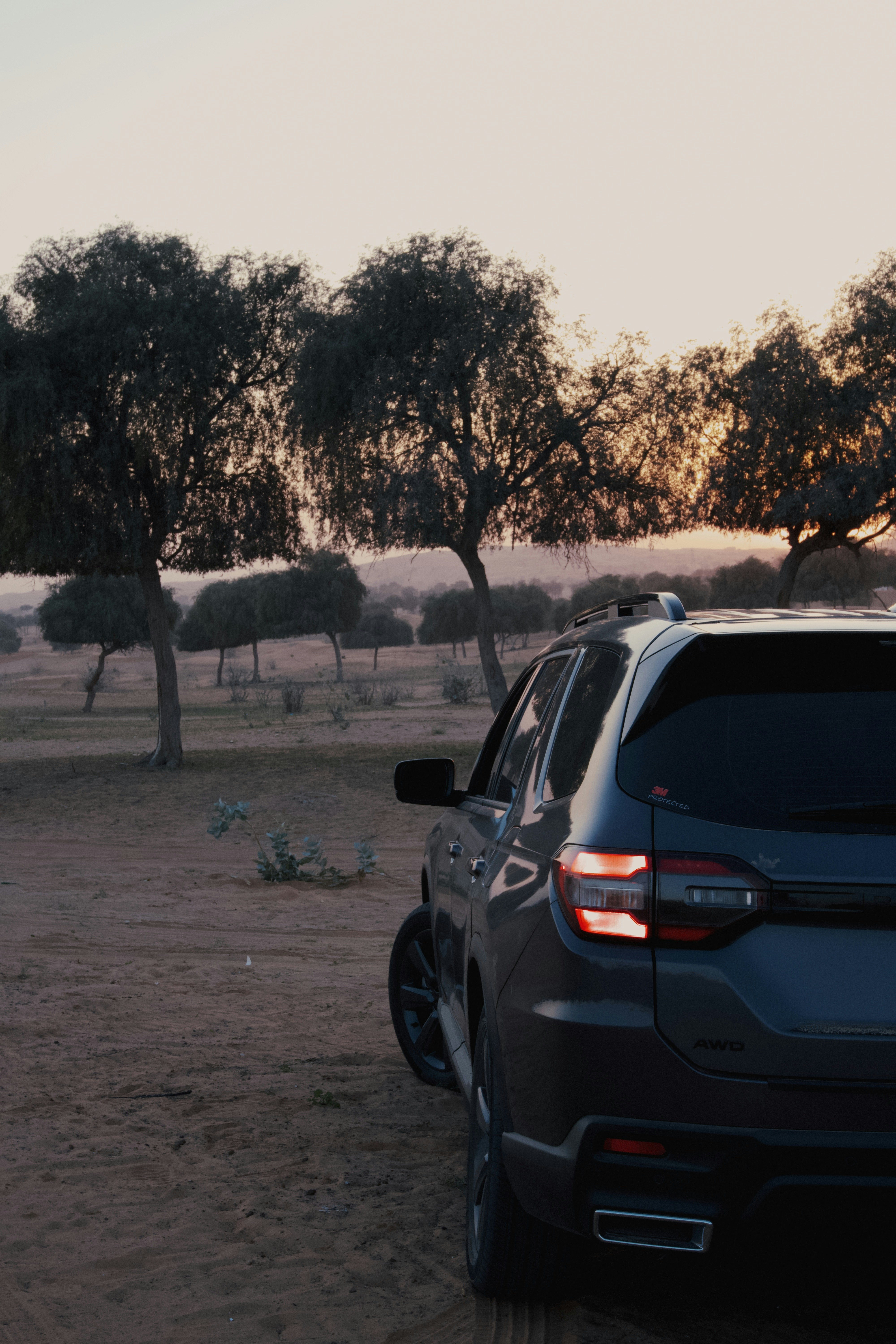 Sunset Odyssey: Backed by Dusty Roads and a Silver SUV
