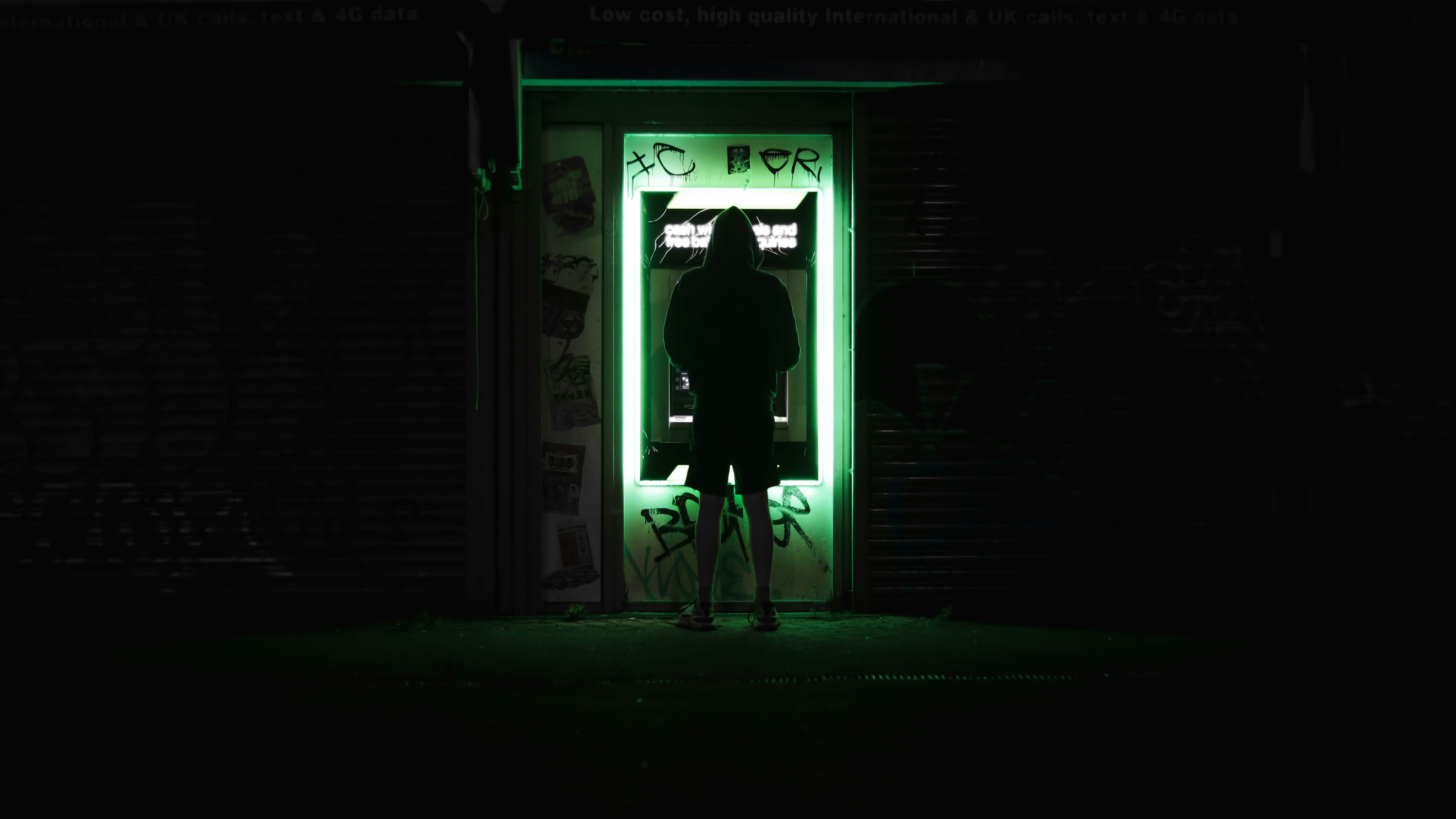 Neon Backlit Silhouette at the Green-Glowed ATM