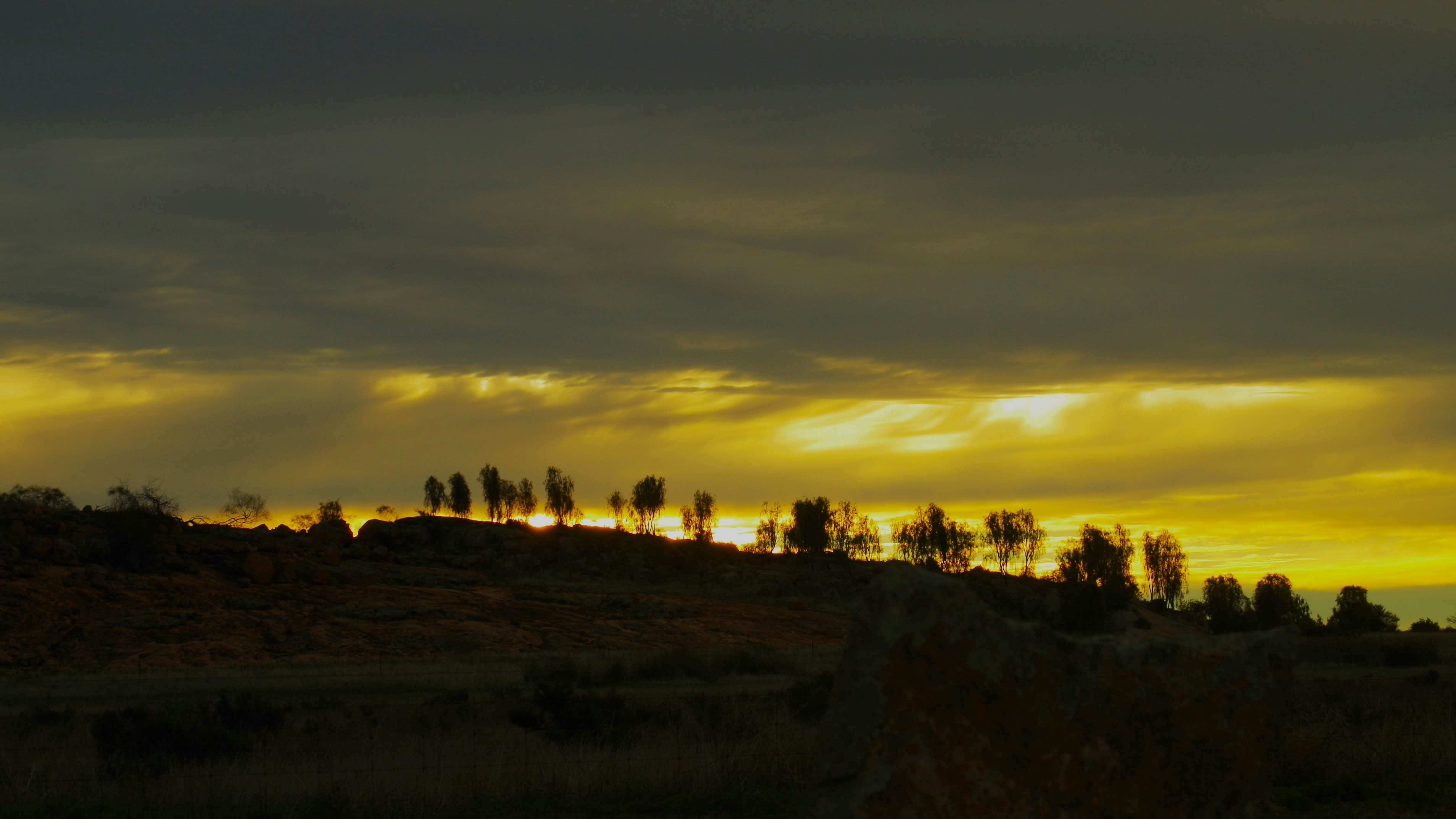 Silhouetted ridge under a molten horizon at dusk