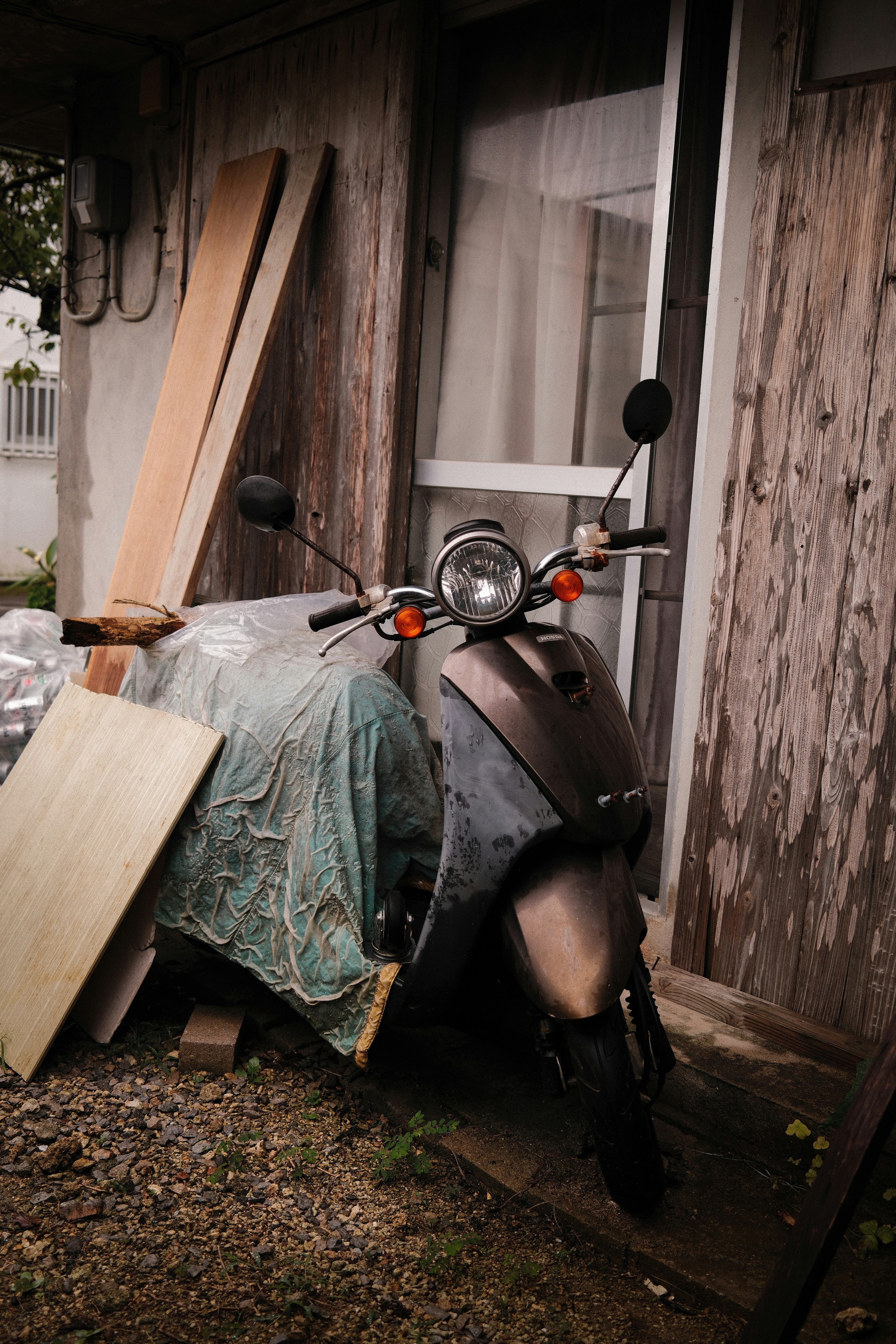 Weathered Scooter Under a Tarp: Quiet Renovation in a Wooden Nook