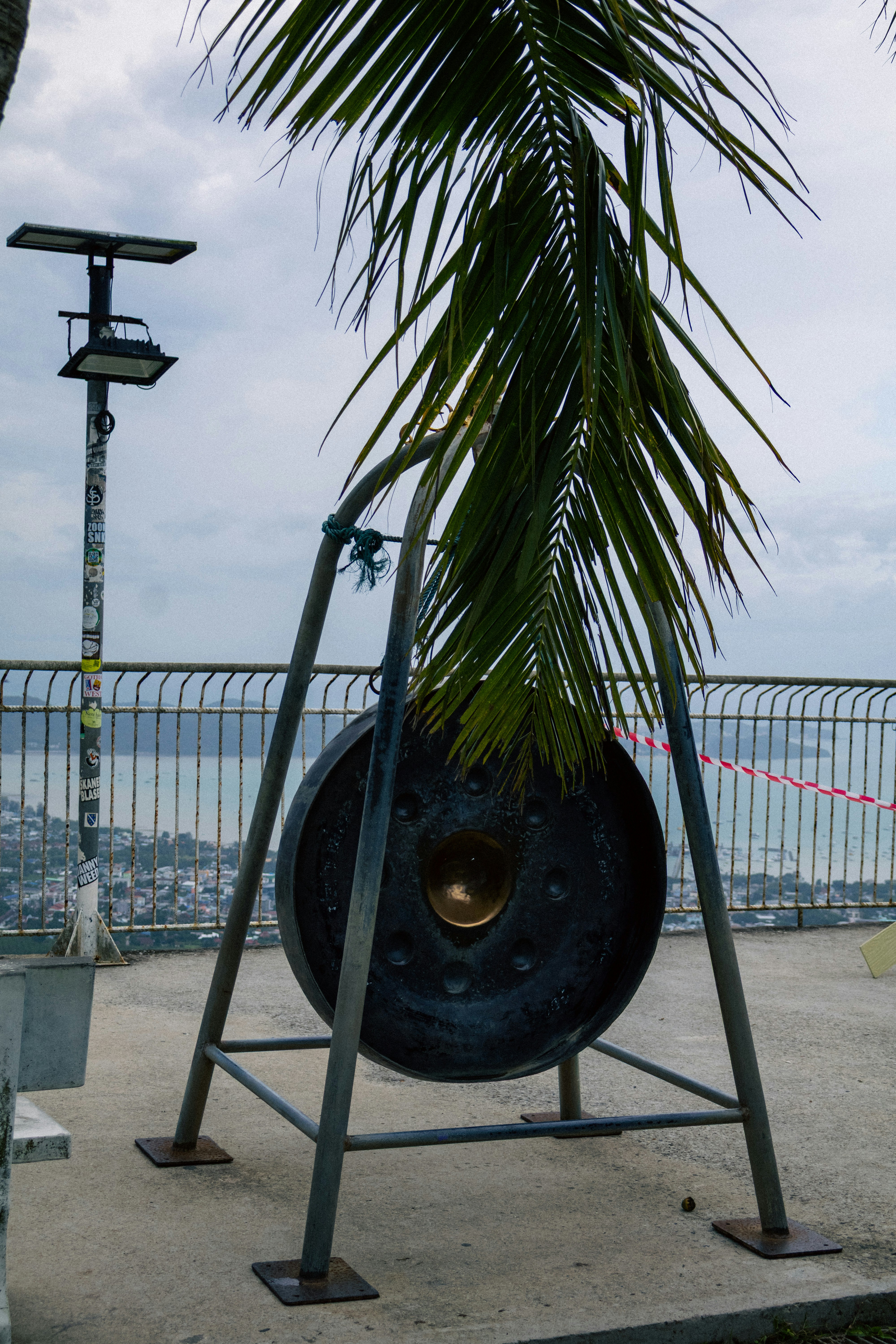 Palm Shade and Mechanical Drum on a Seaside Promenade