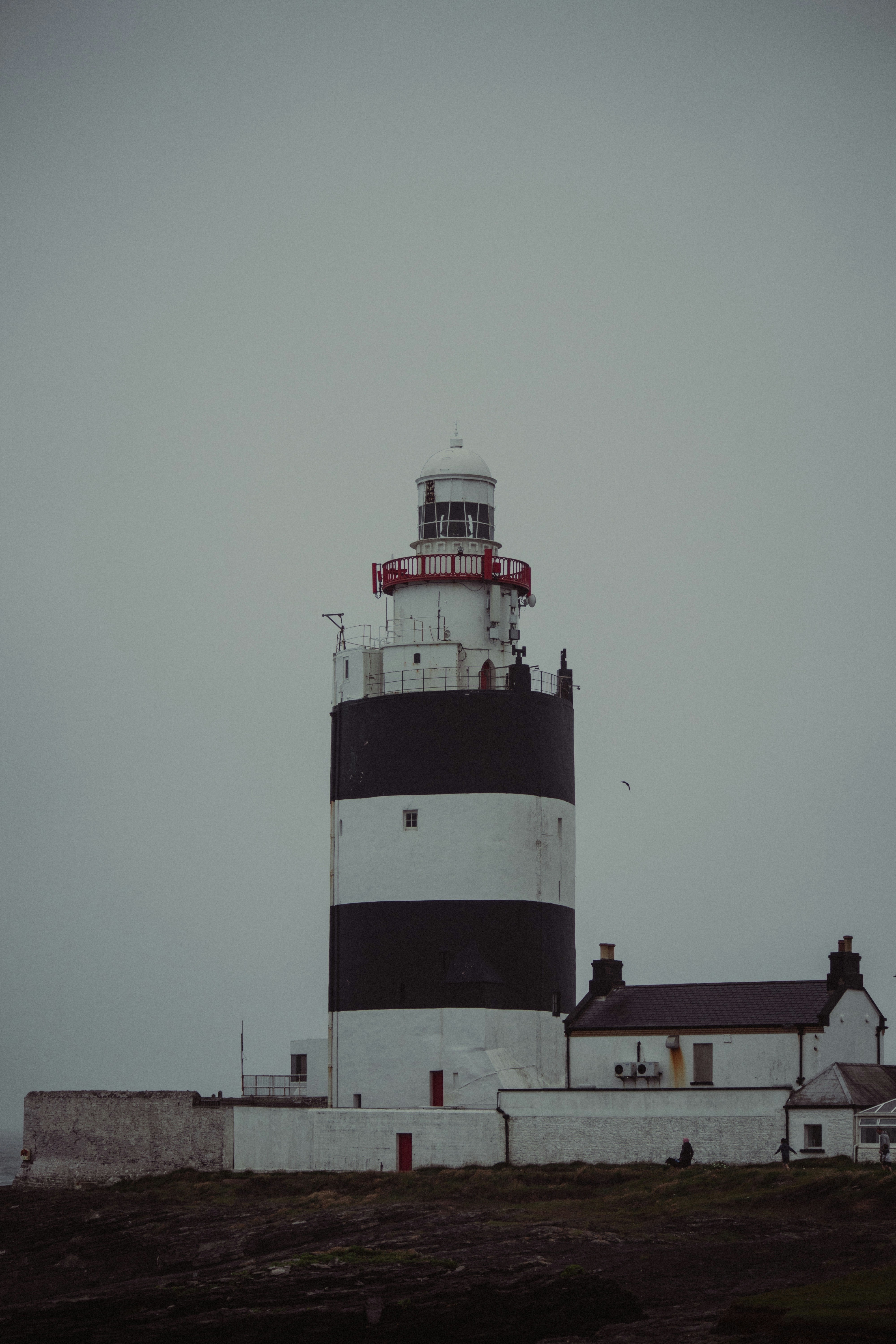 Beacon on the Edge: A Coastal Lighthouse Standing Against the Overcast