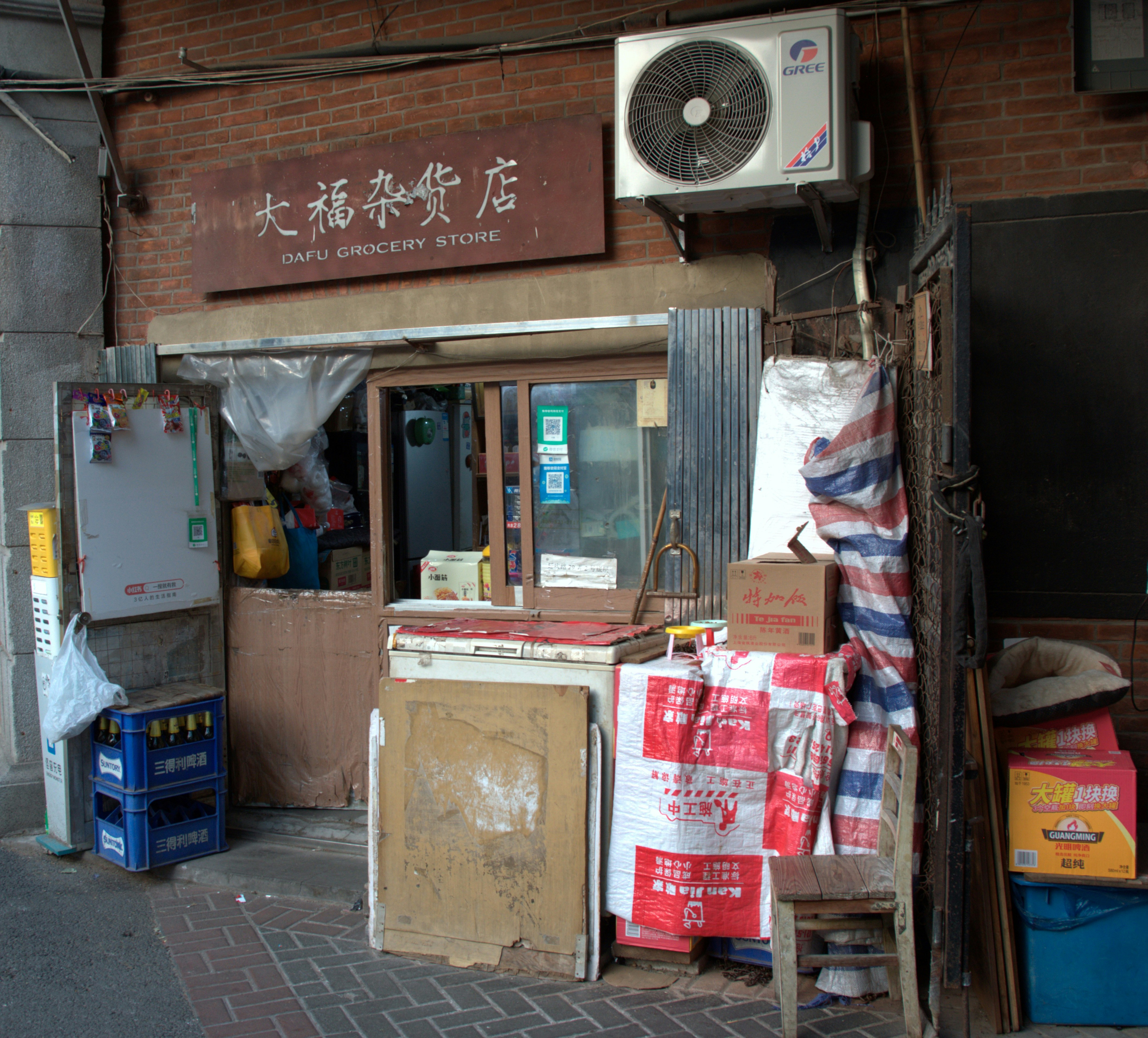 Duanfu Grocery: A cluttered storefront with a weathered counter and stacked packages