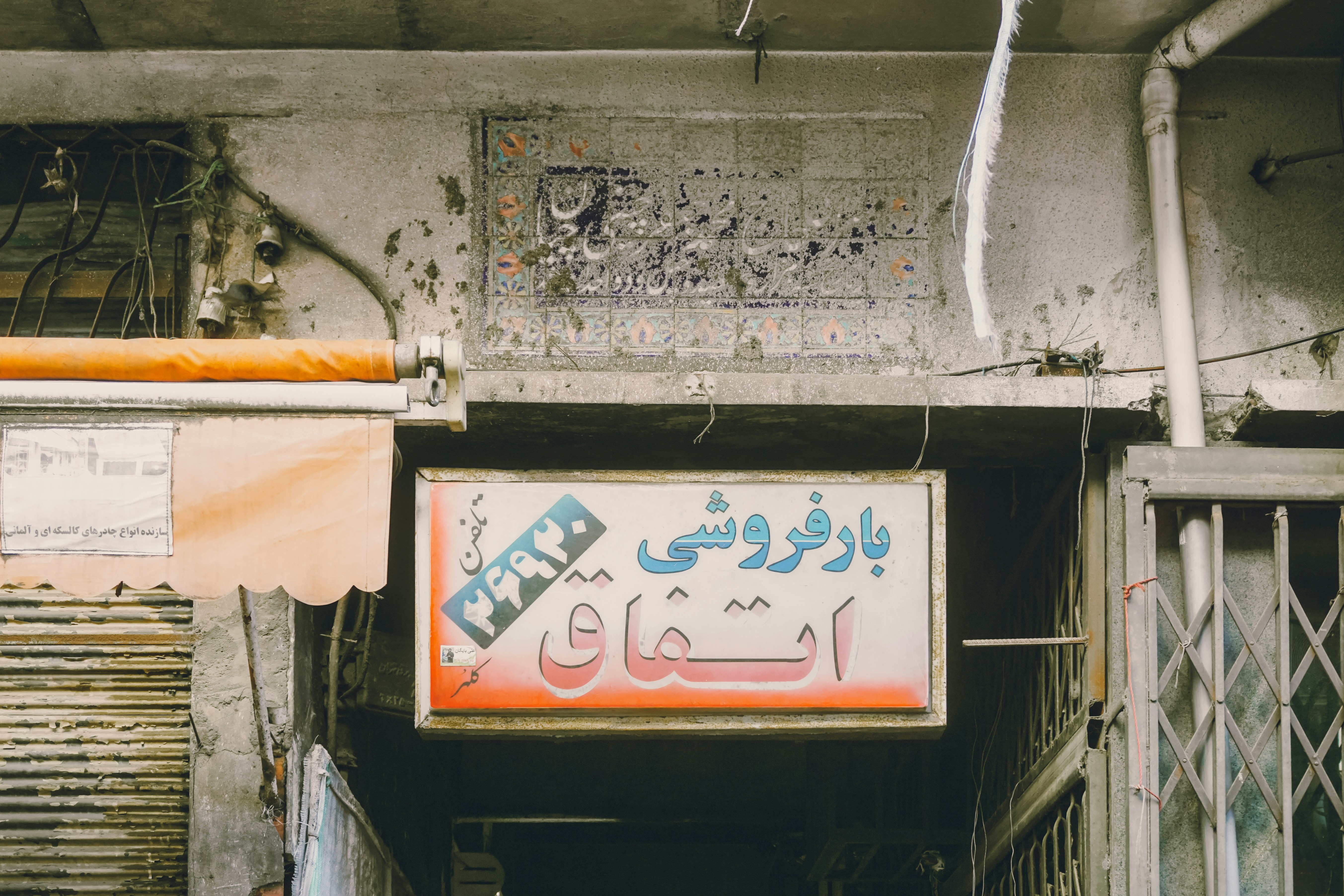 Arabic Script Sign Above a Dim Alleyway Entrance