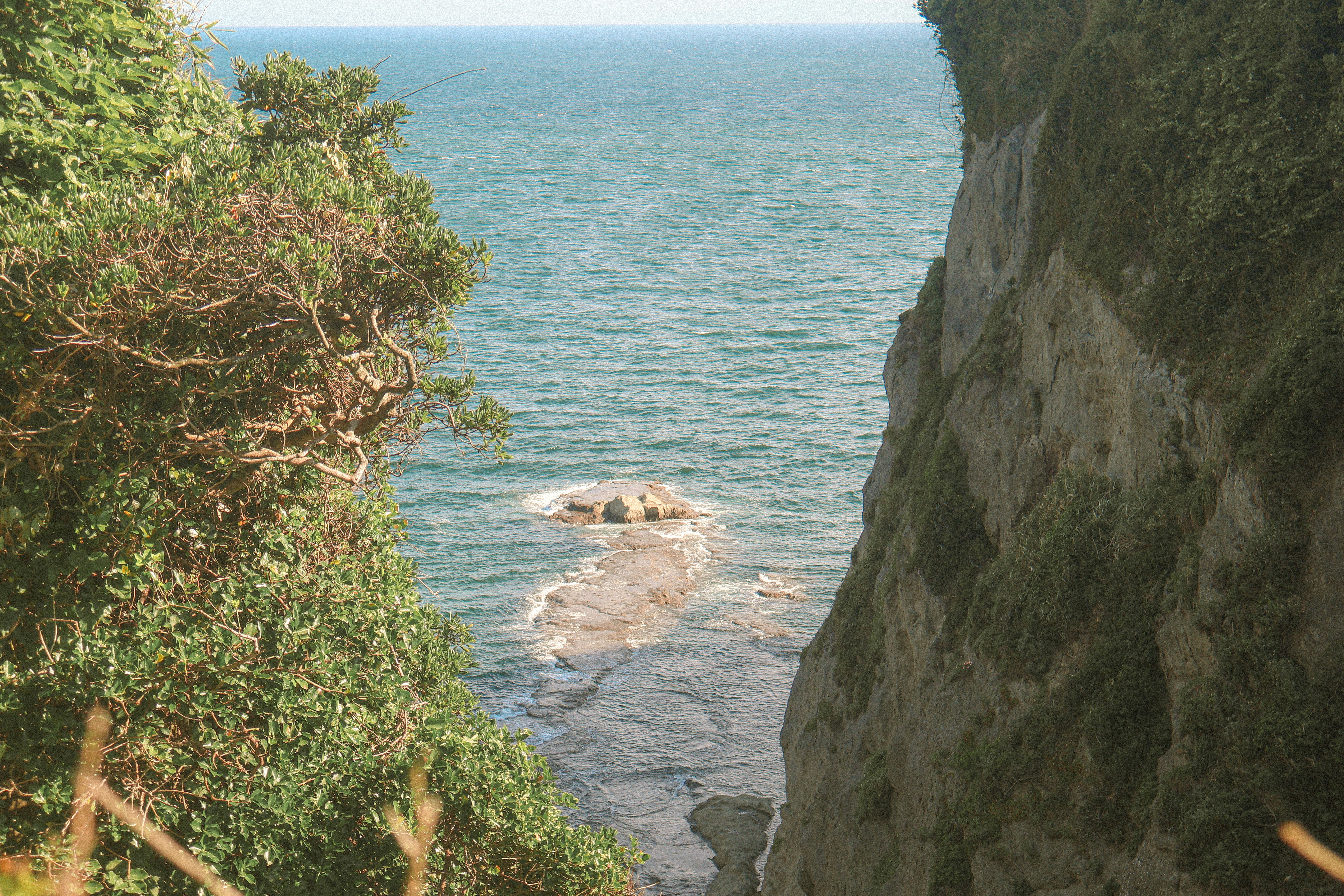 Harbor in the Gap: Quiet Sea Through a Framed Cliff