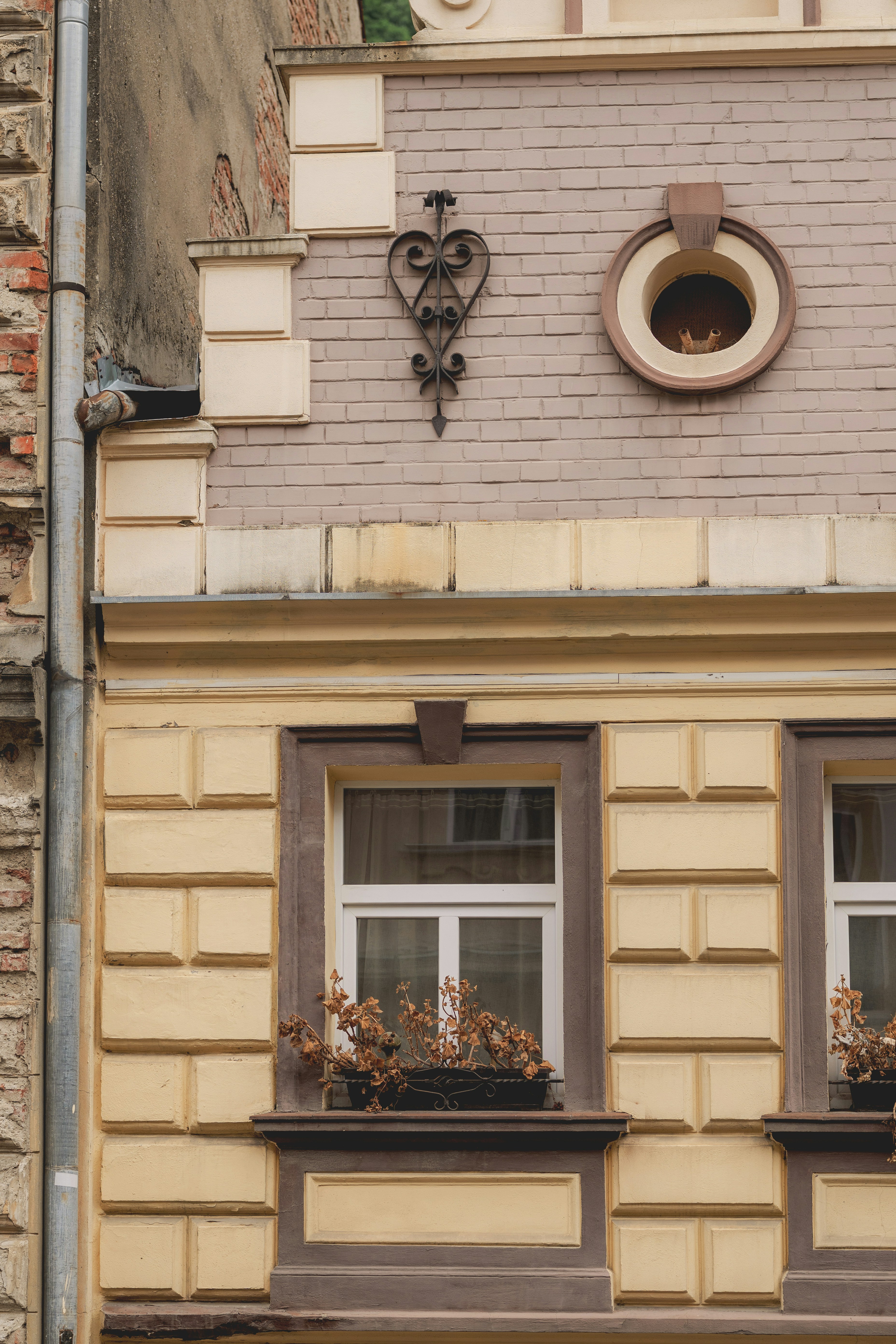 Floral Balcony and Circular Window on a Sundrenched Historic Facade