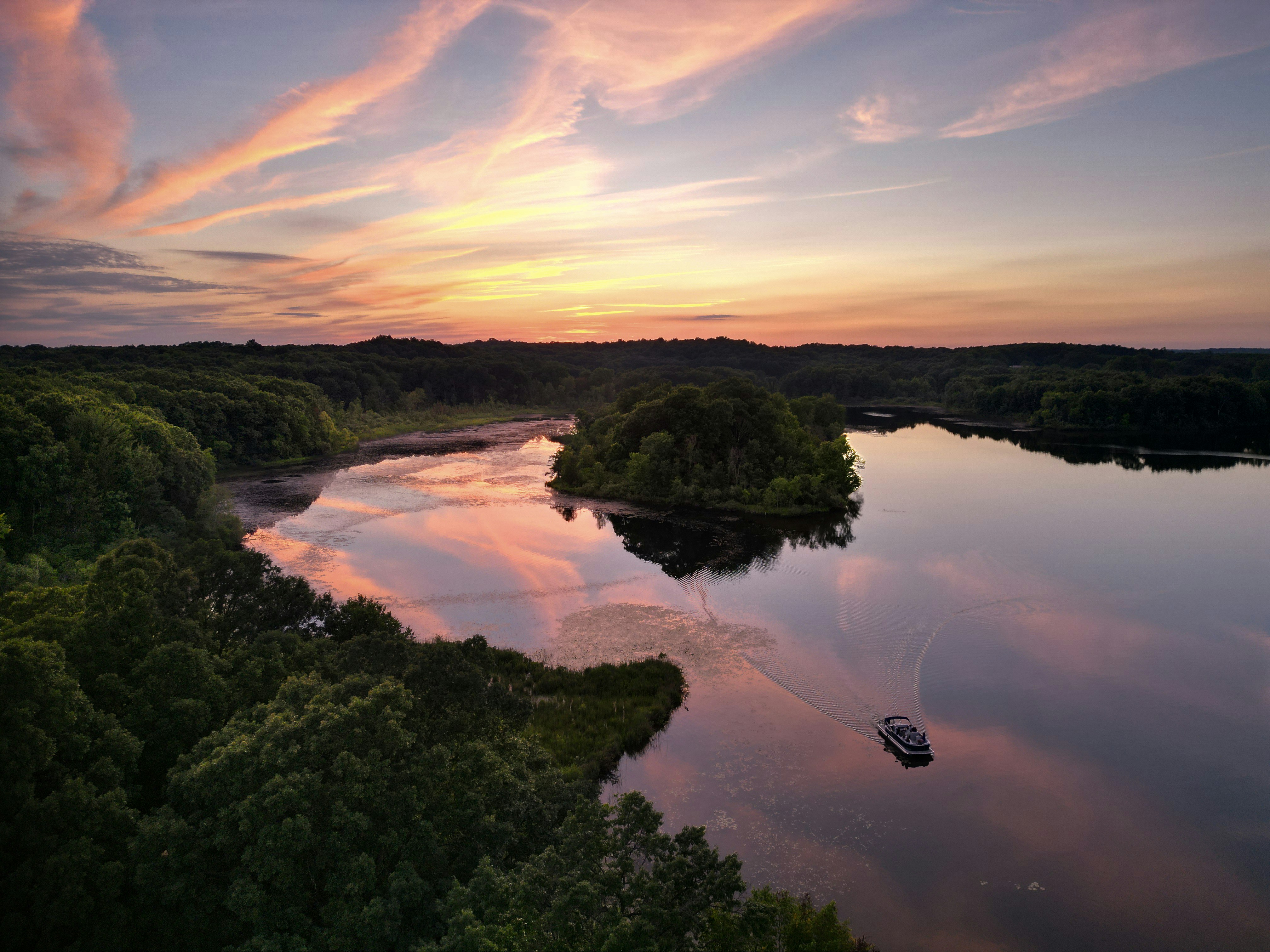 Sunset Drift: A Lone Boat Tracing Quiet Currents Through Dusk