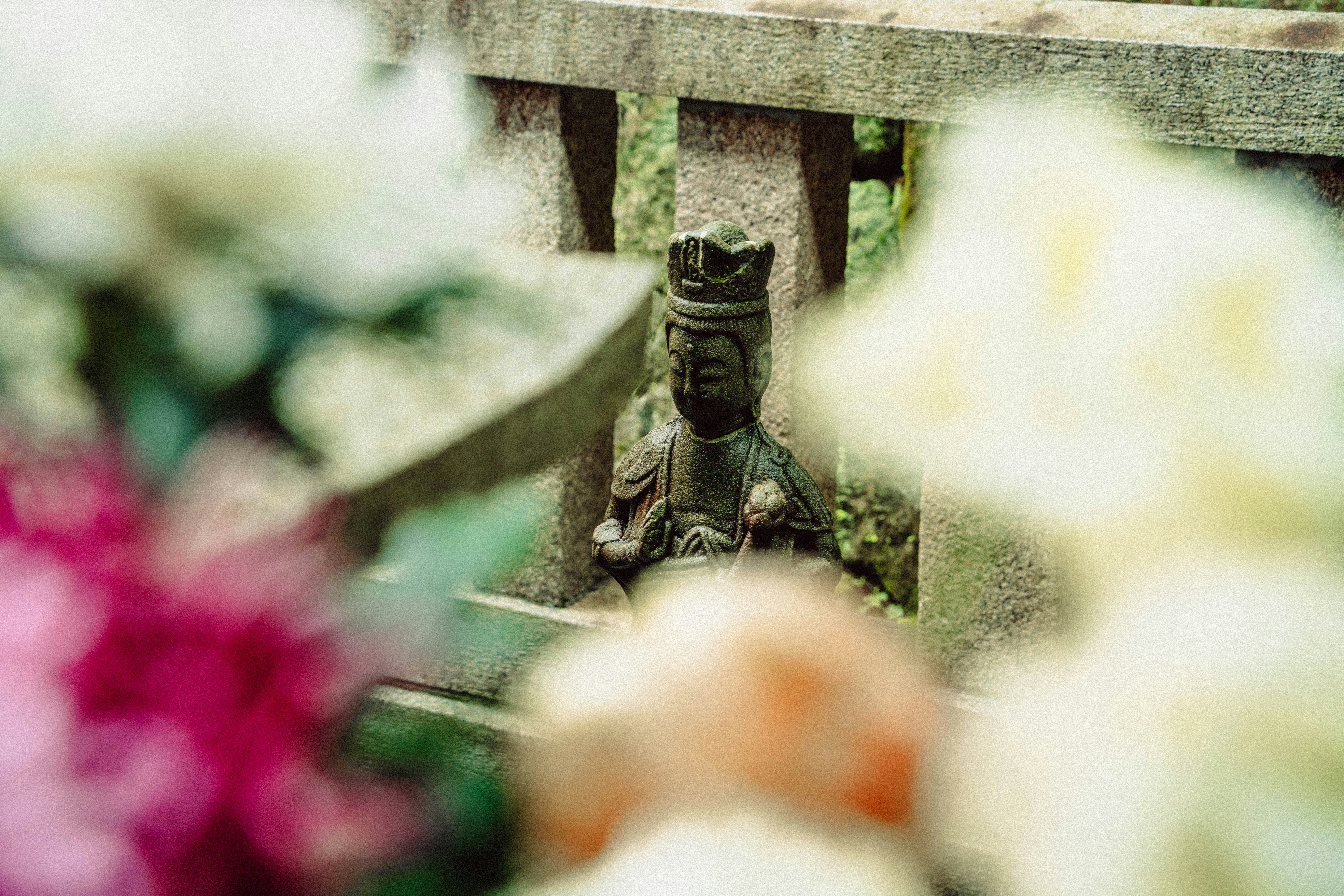 Soft Focus Shrine: A Shrouded Statue Hidden Among Petals