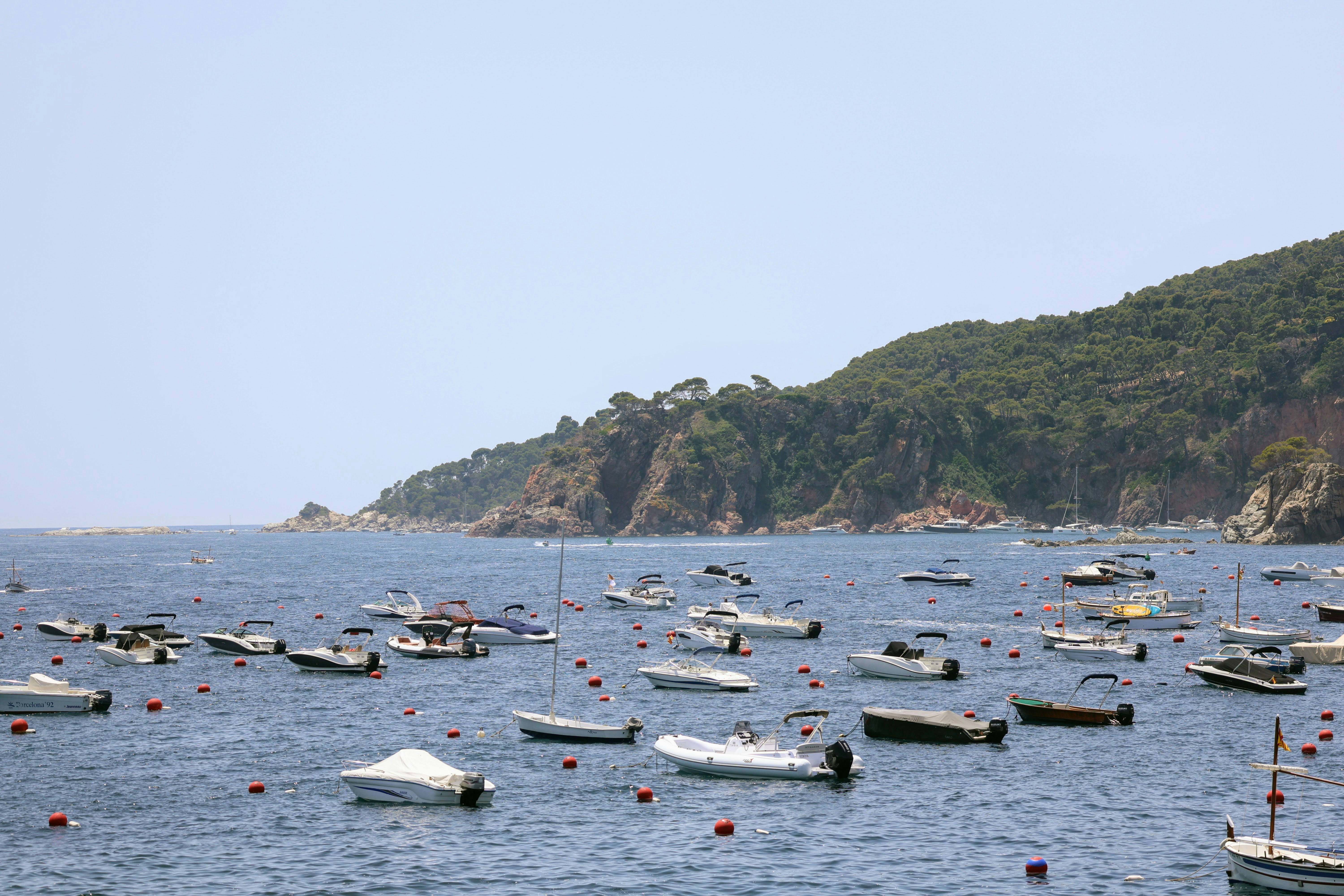 Harbor Mosaic: Boats Rest at the Foot of a Cliff