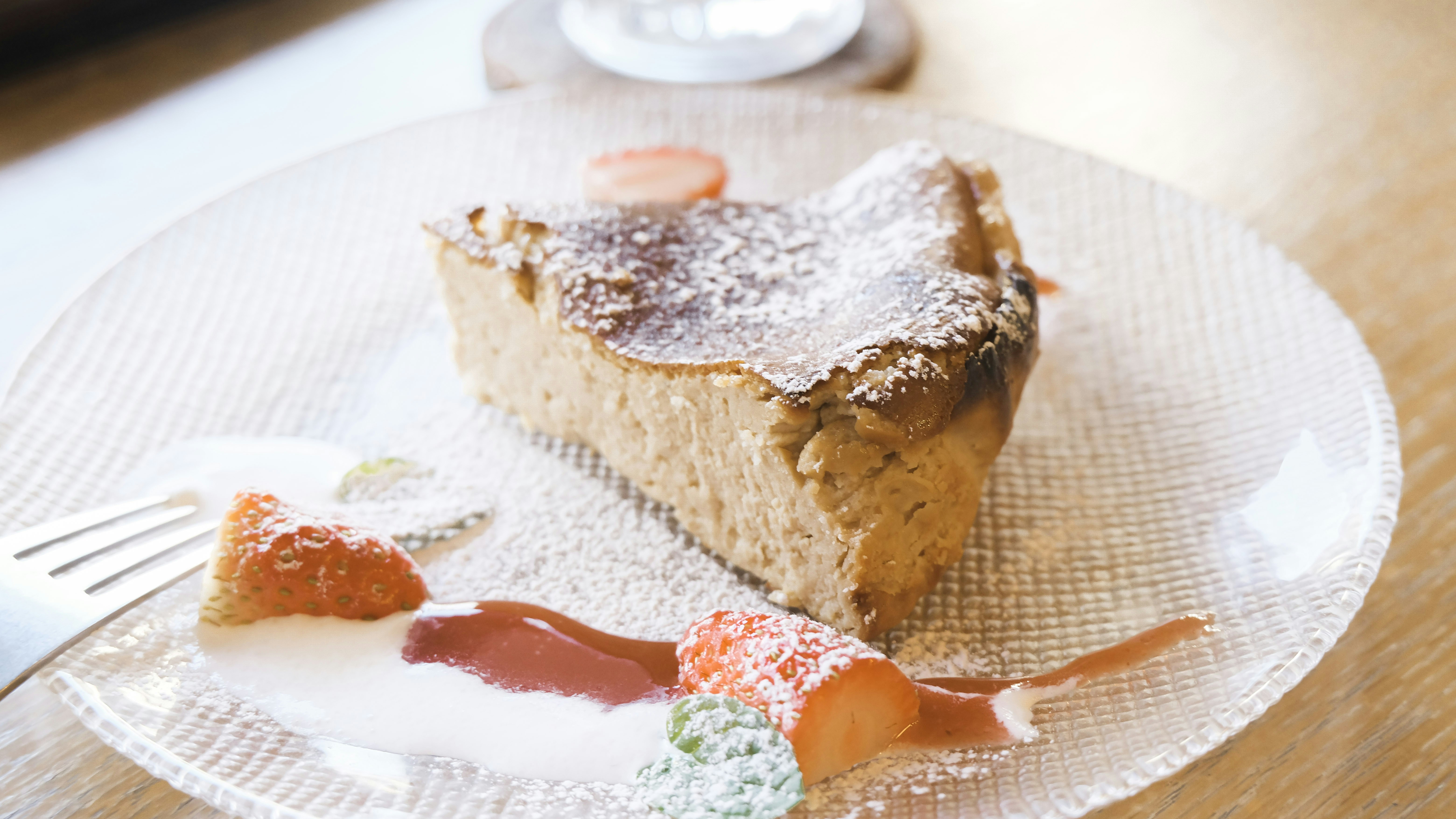 Golden Slice: Cheesecake Candlelight on a Powdered Plate