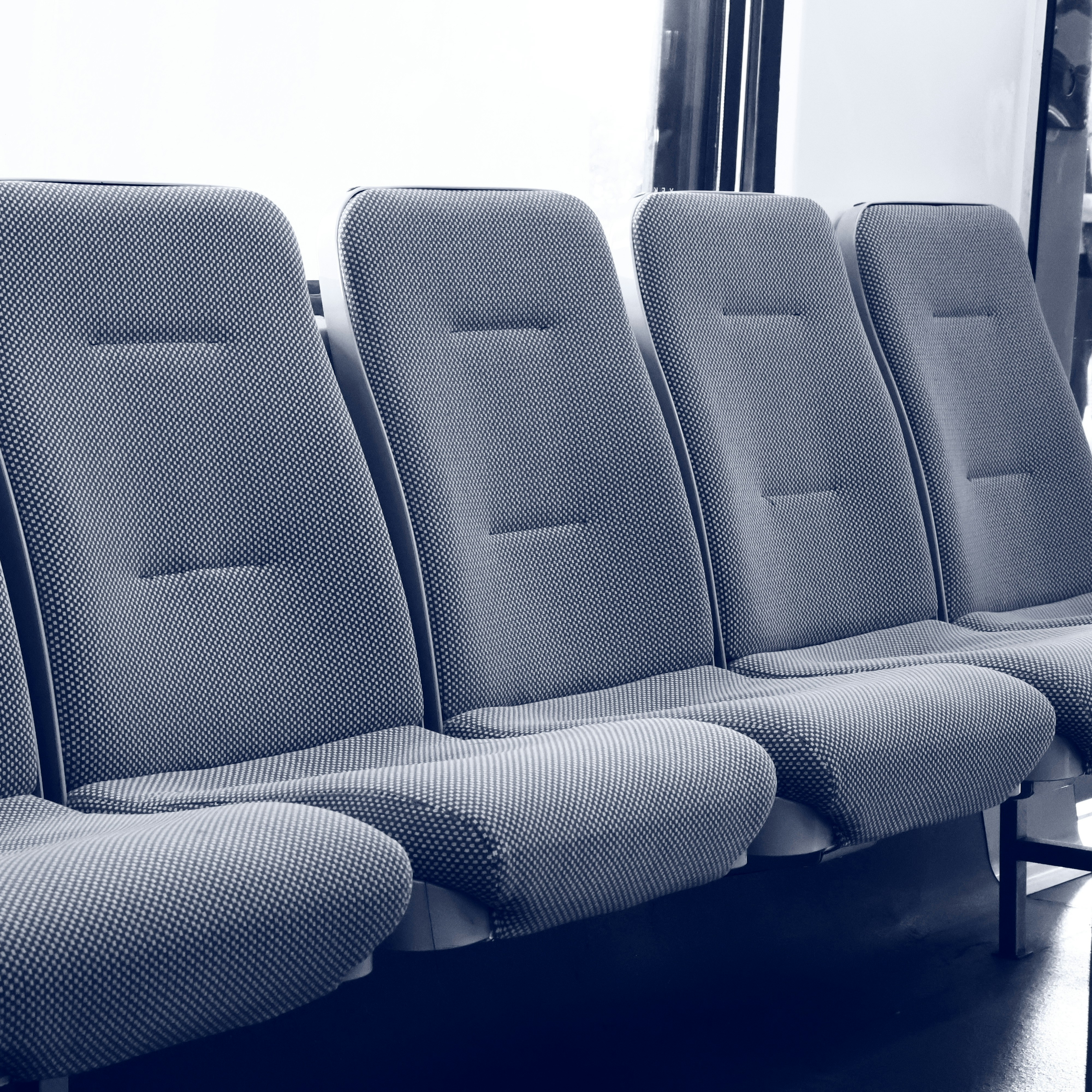 Row of patterned bus seats in cool-toned interior