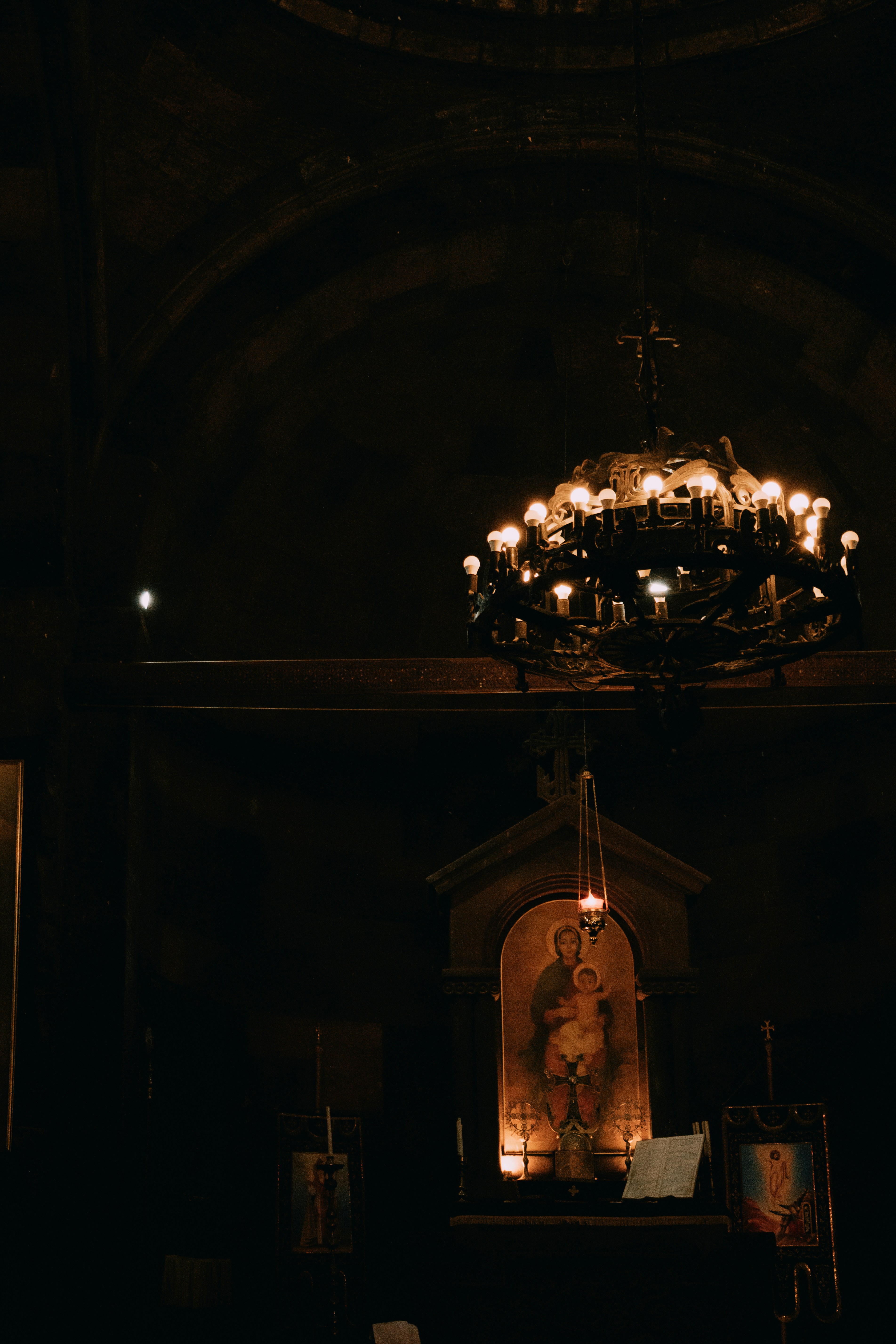 Dim Cathedral Glow: A Candlelit Shrine Beneath a Grand Chandelier