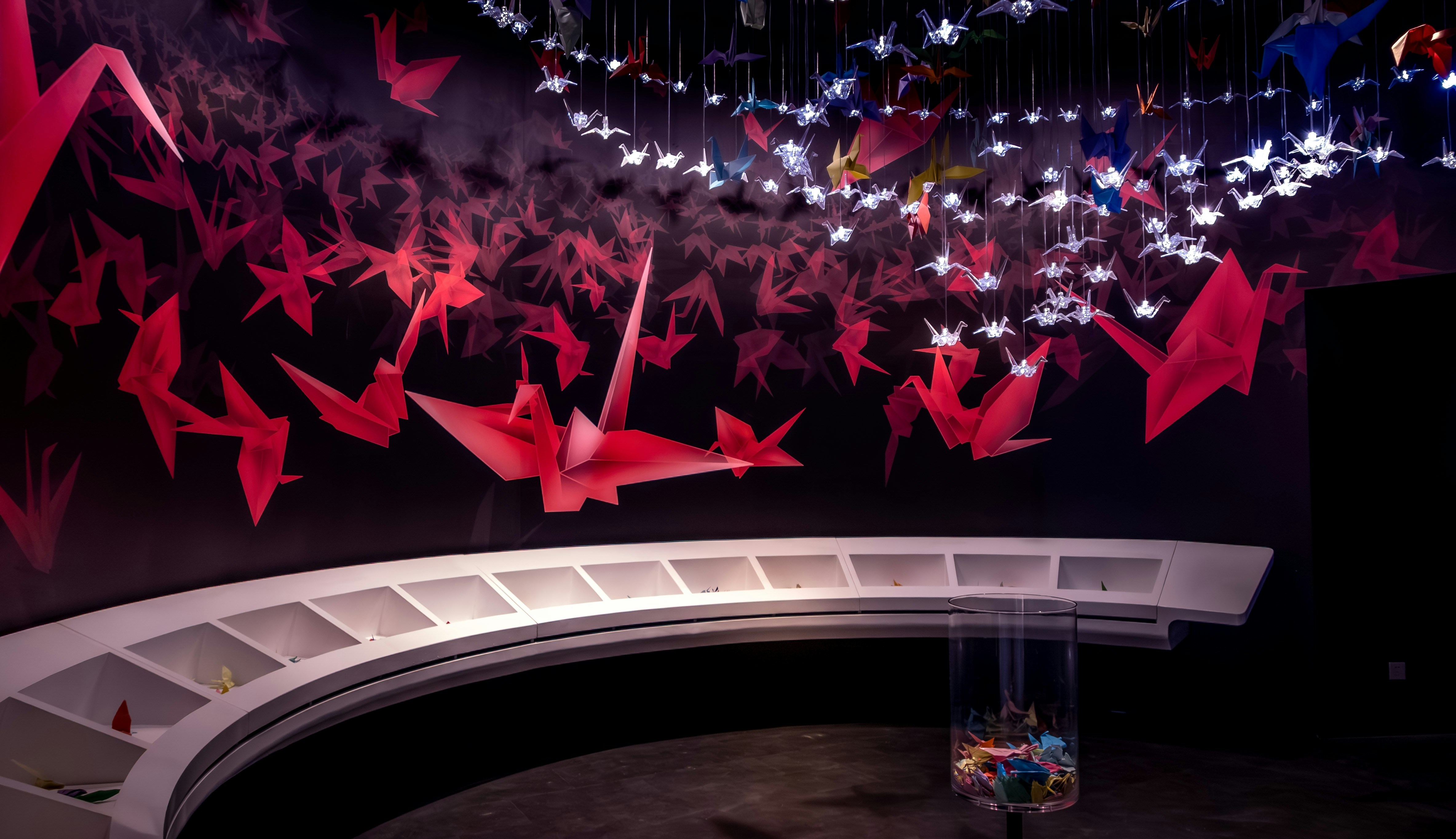 Origami Choir: a tunnel of crimson cranes over a curved gallery