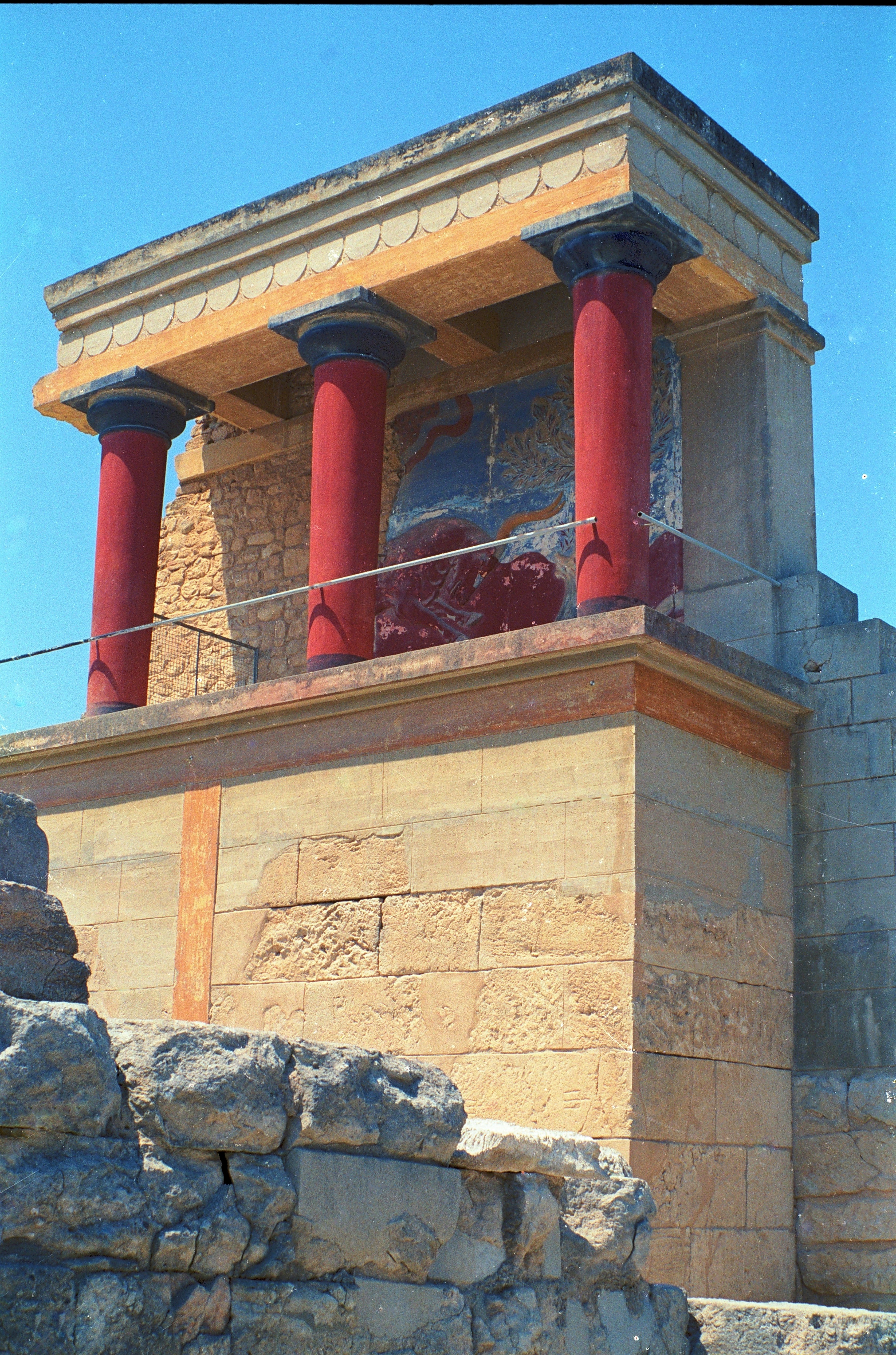 Ancient Temple Façade Framed by Red Columns under Clear Blue Sky