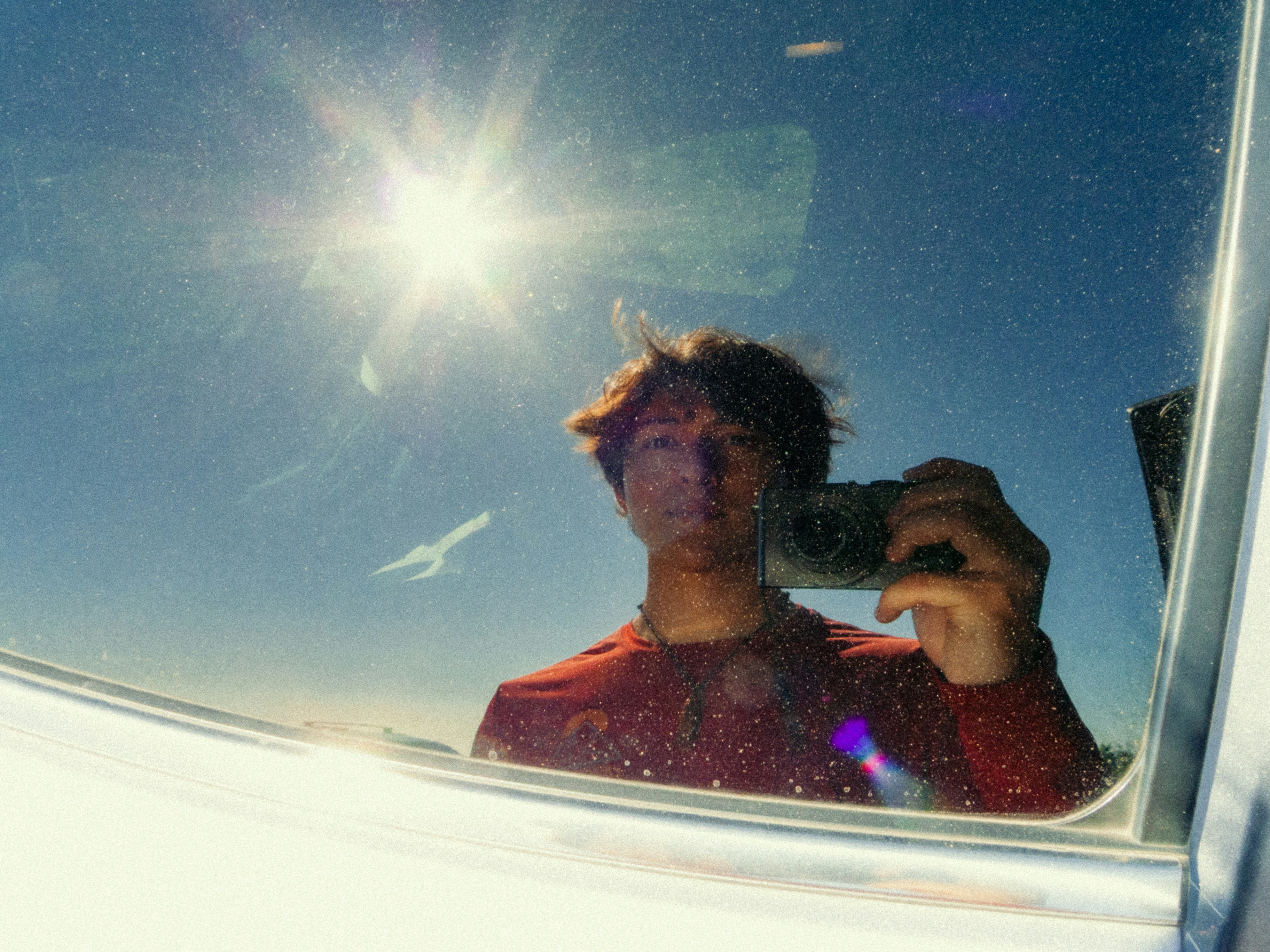 Self-Portrait on a Shiny Car Window at Noon