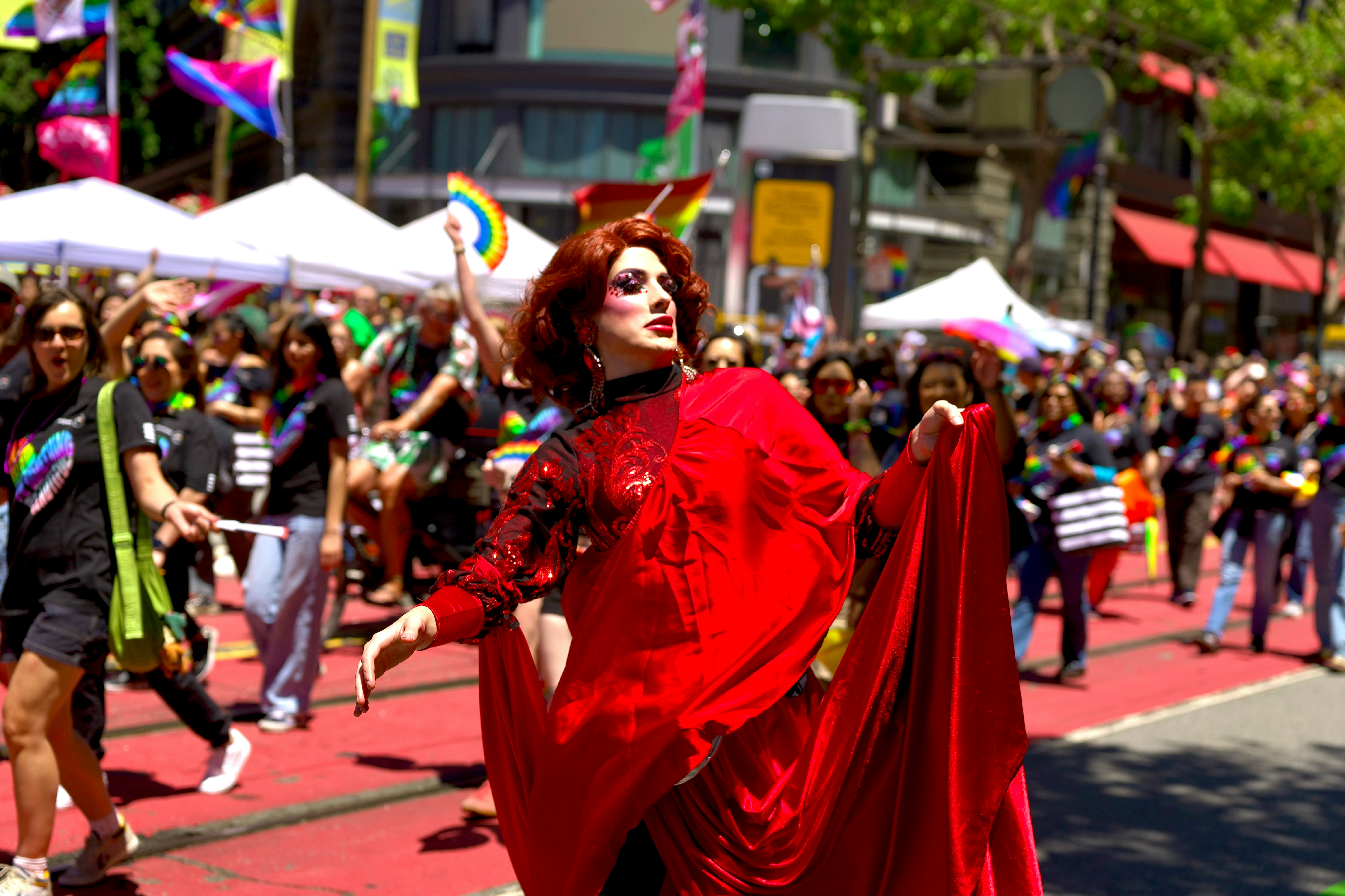 Red-draped performer strides through a vibrant parade