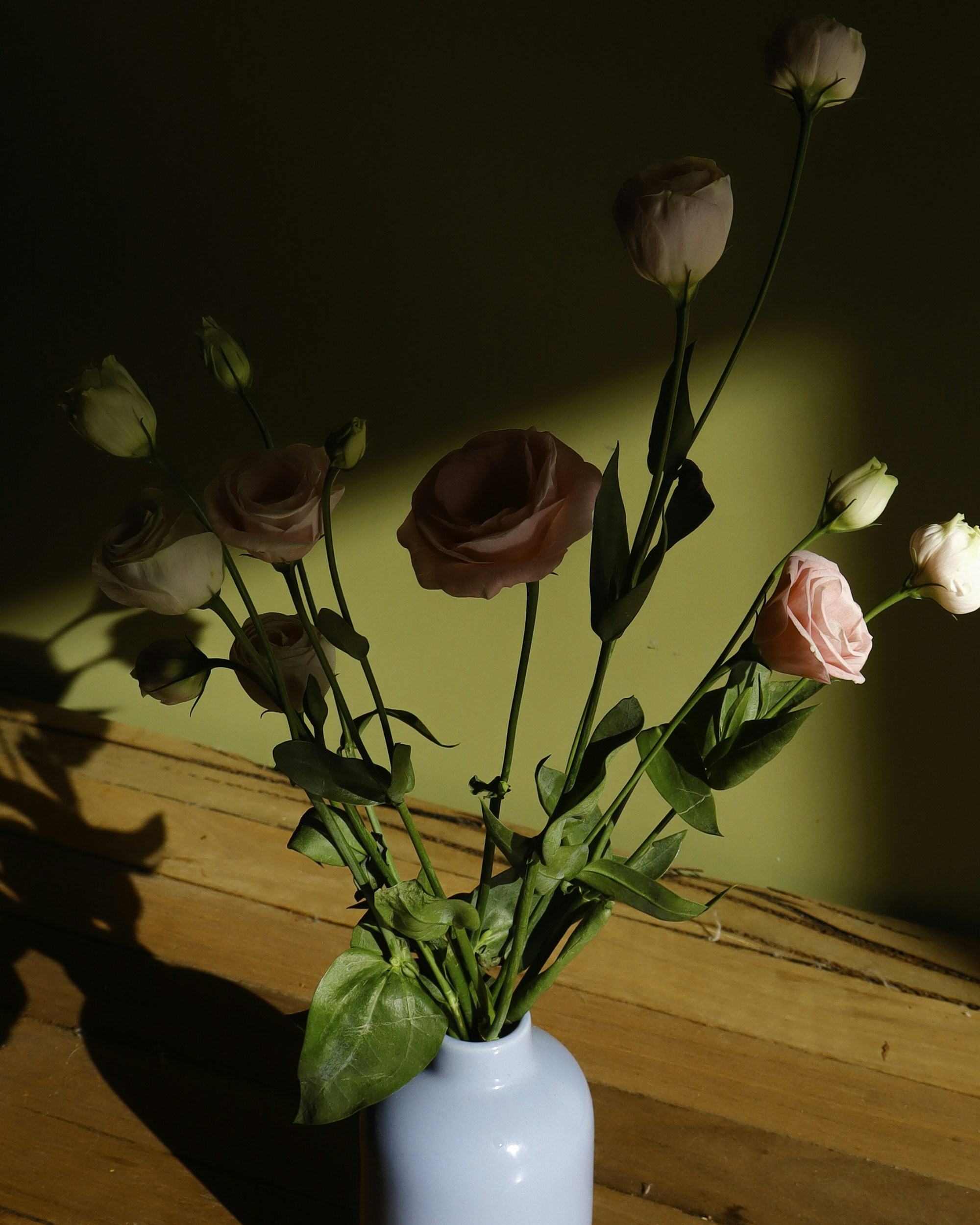Centerpiece in Sunlit Glass: A Bouquet of Roses in a Pale Blue Vase