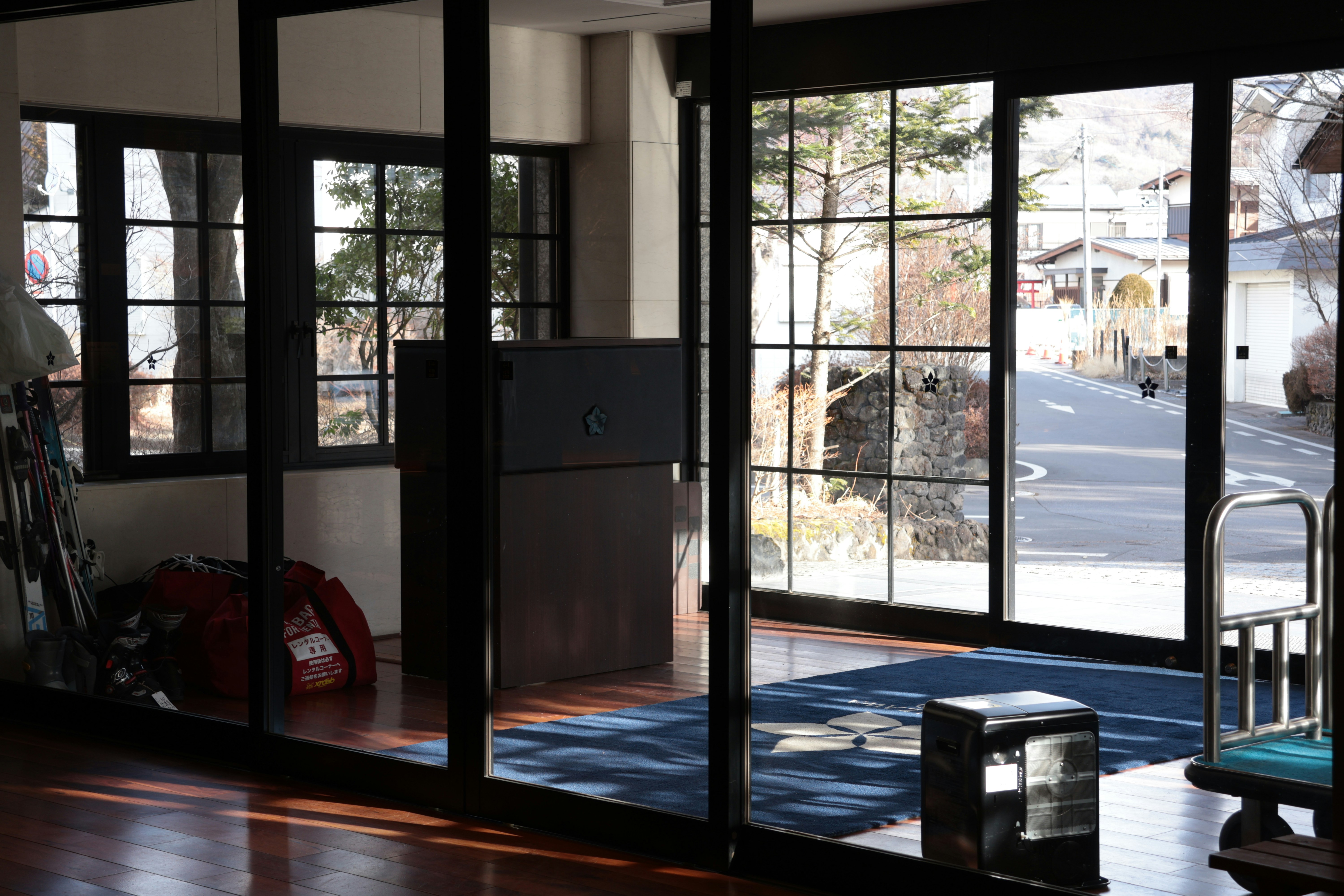 Quiet Lobby Through Glass Doors into a Sunlit Street