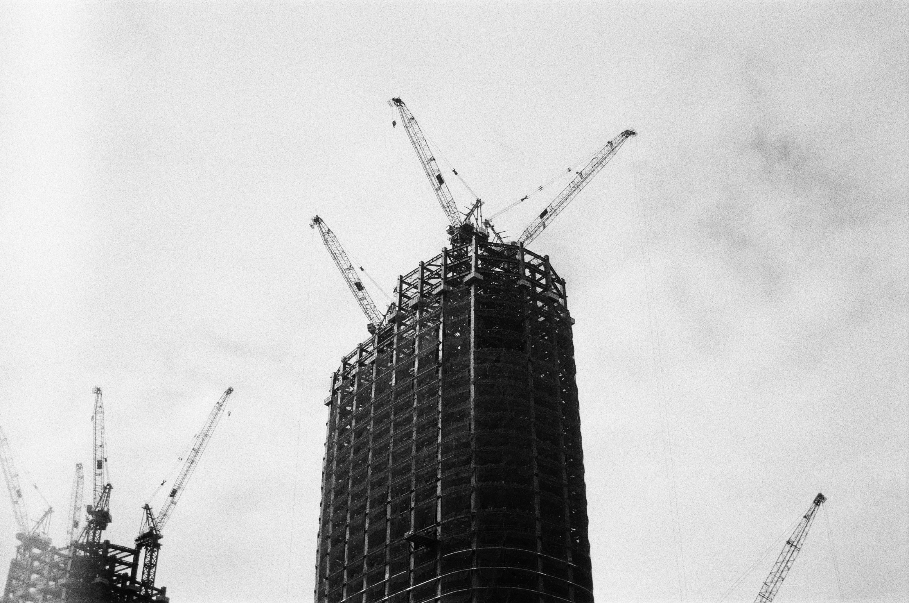 Cranes and Ghostly Tower: A Skyline Rising in Silence