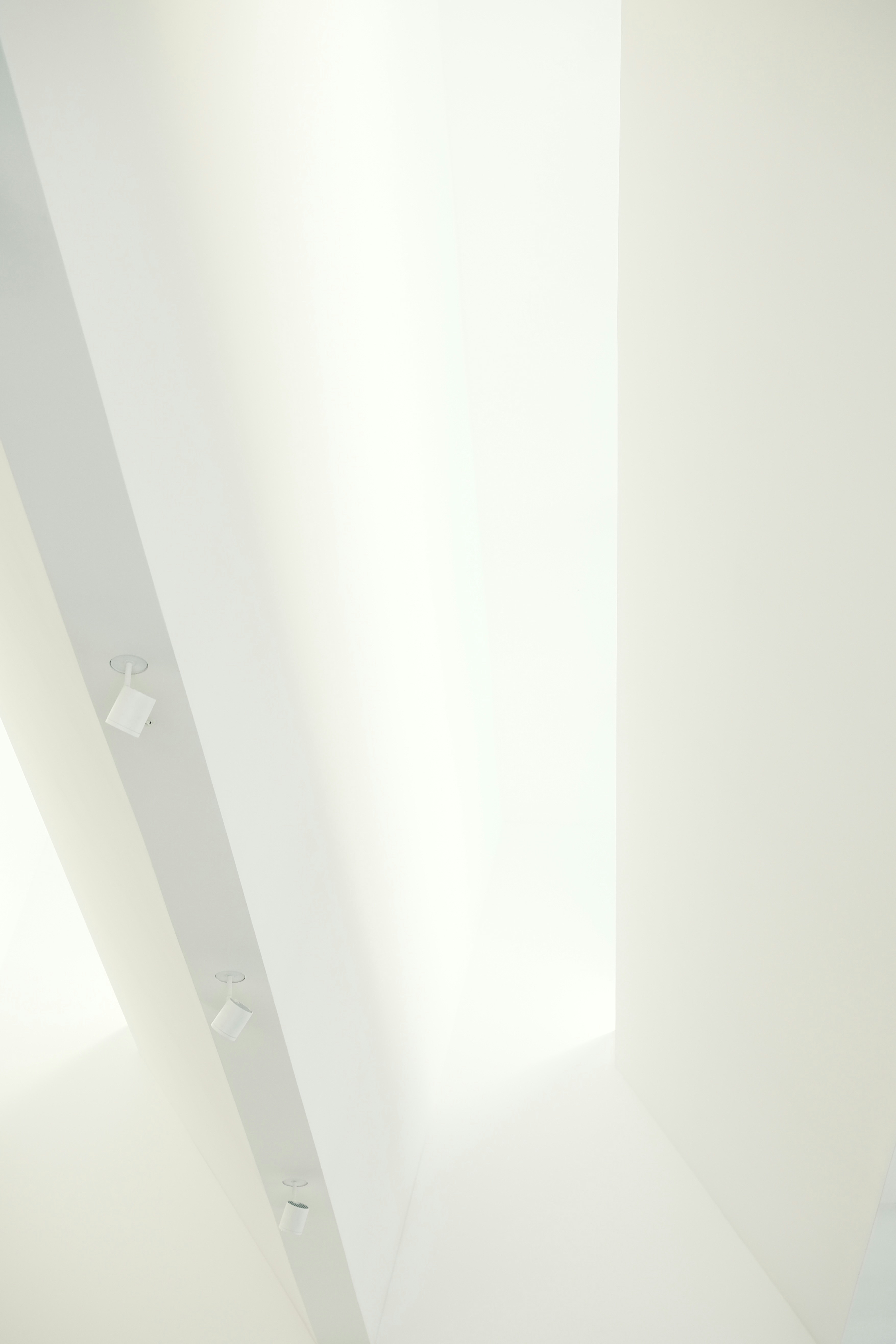 Minimalist skylight: vertical architectural light strips in a white interior