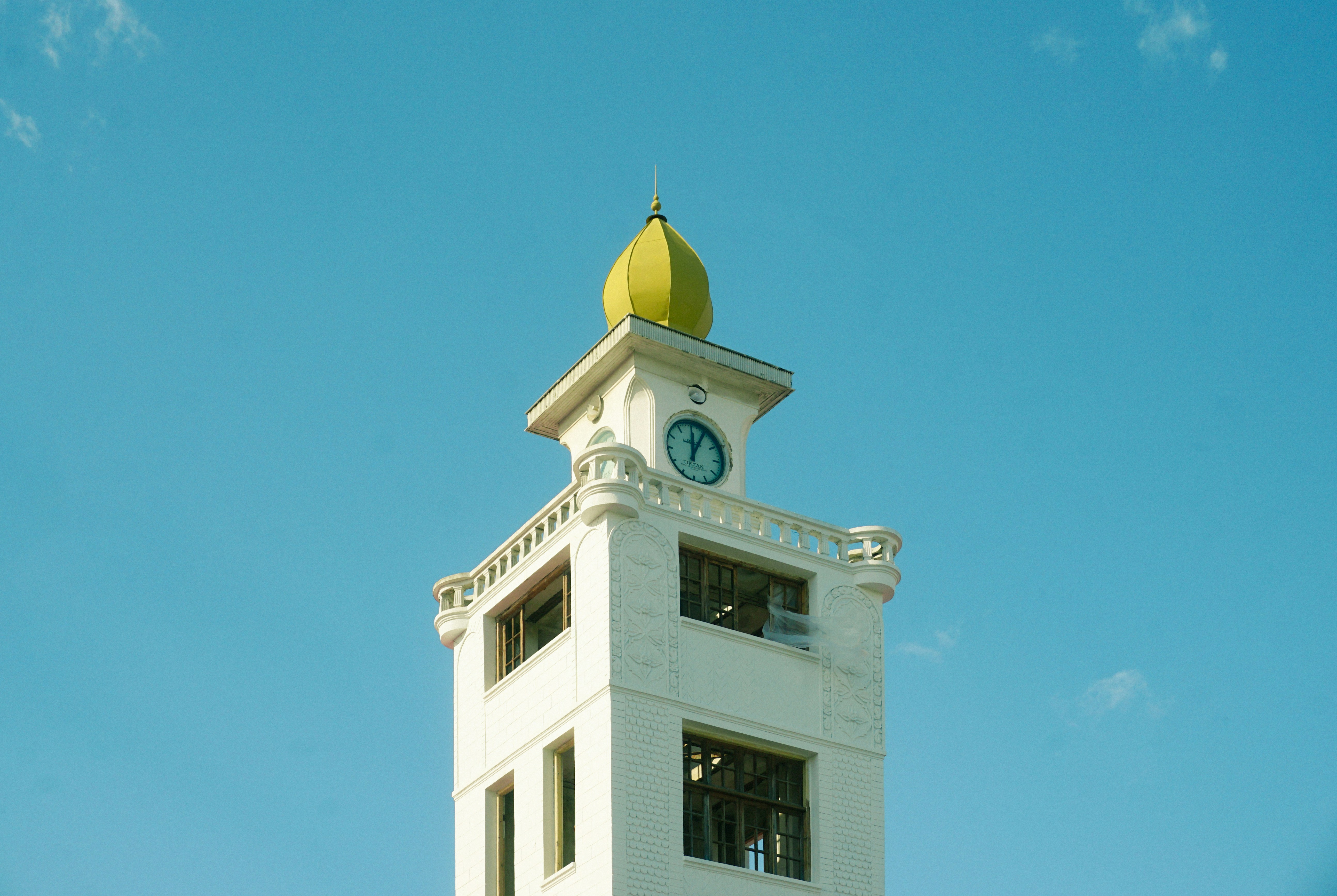 Clock-topped white tower under a clear blue sky