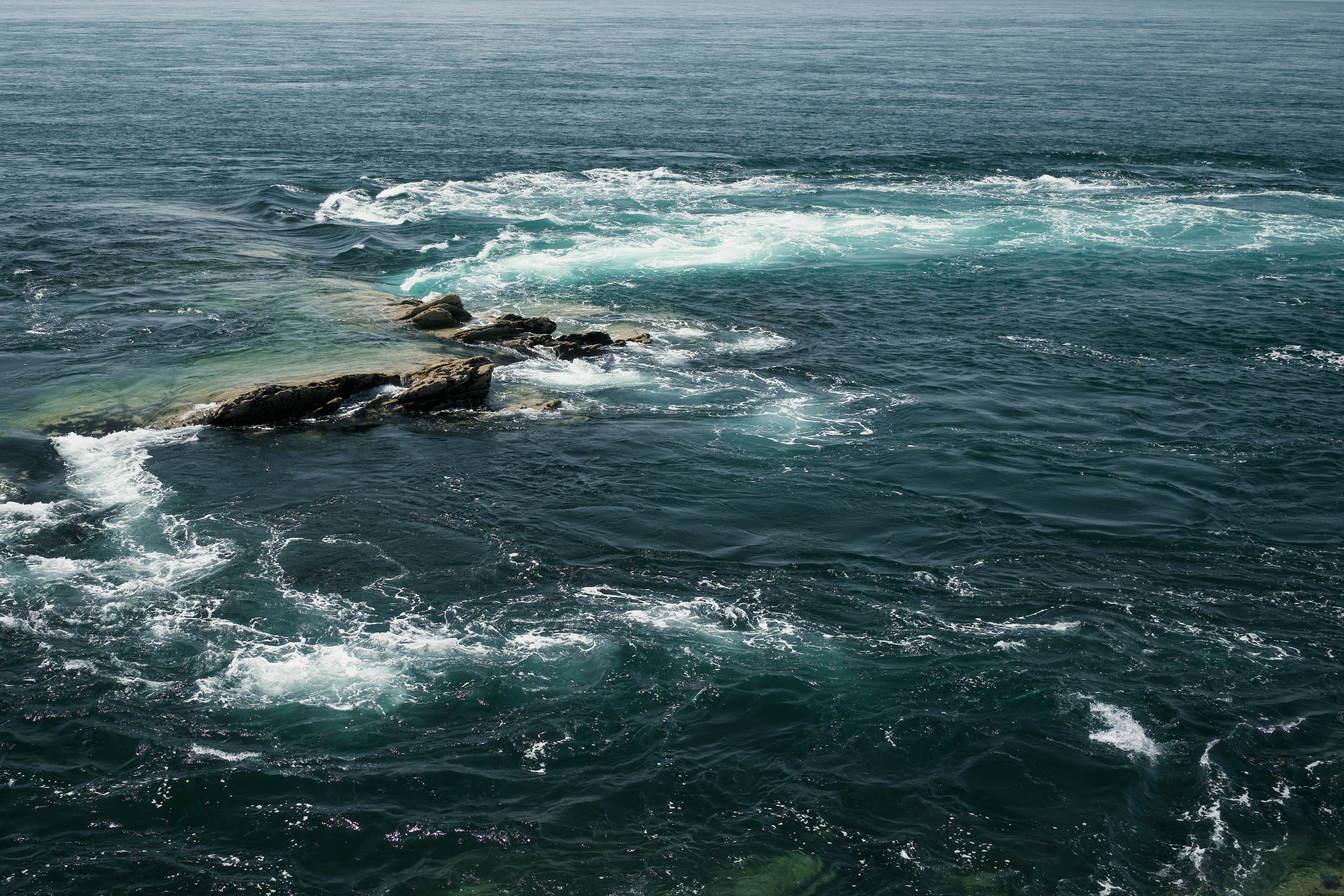 Hidden Reef Breaks the Surface: A Quiet Sea Texture of Turquoise Currents