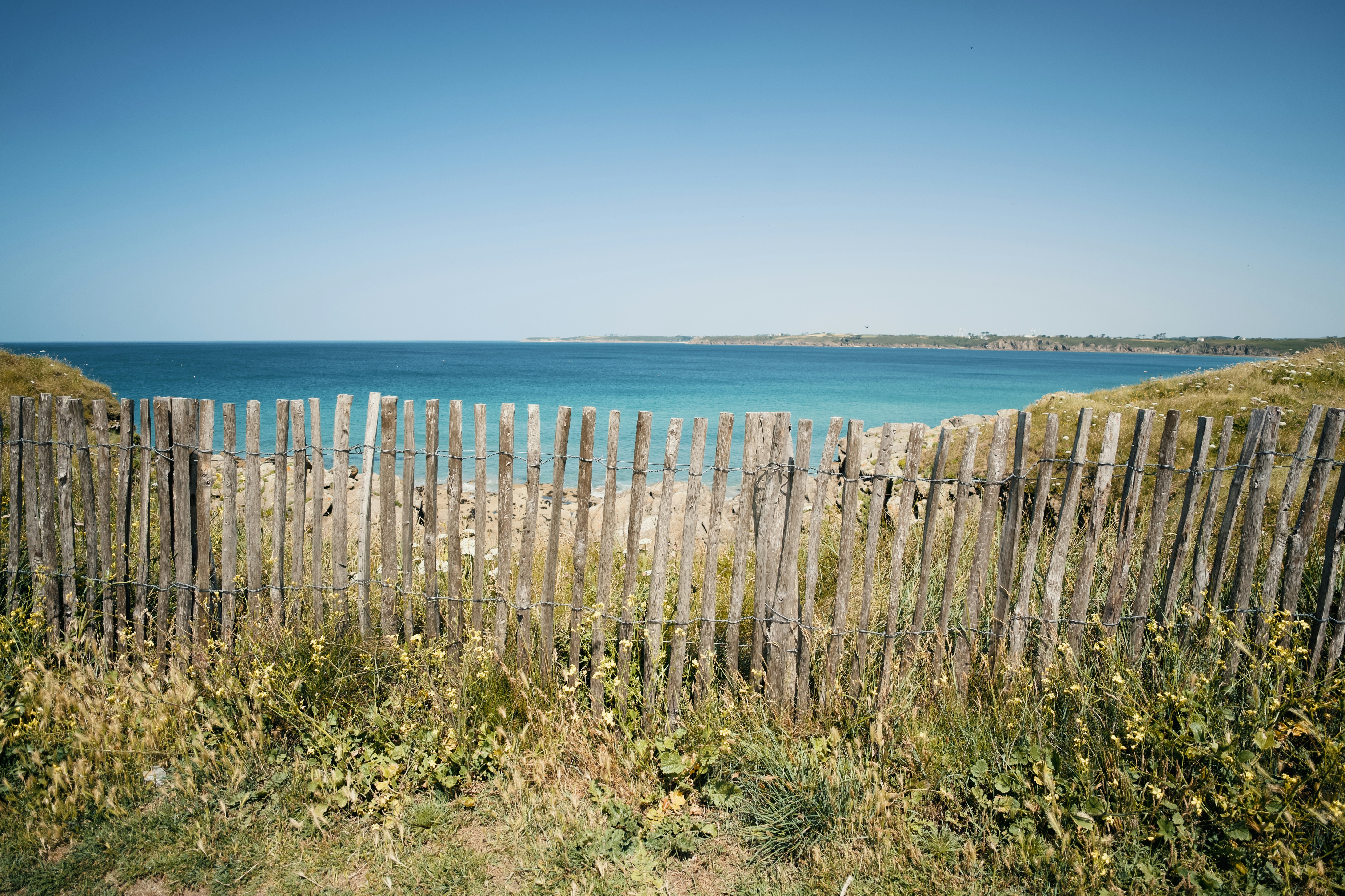 Weathered Fence Framing a Coastal Horizon
