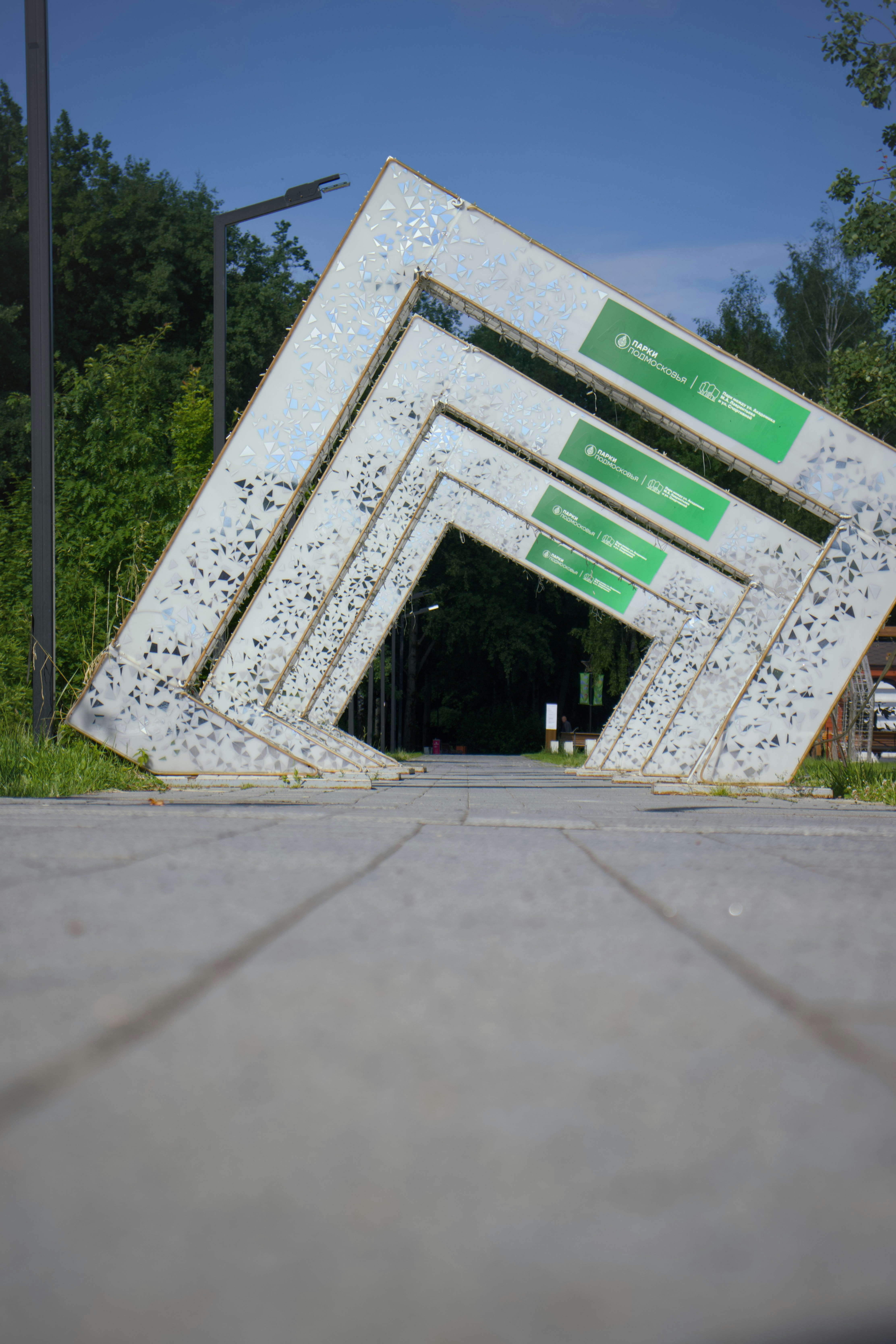 Angular Welcome: a series of rusted frames framing a green corridor