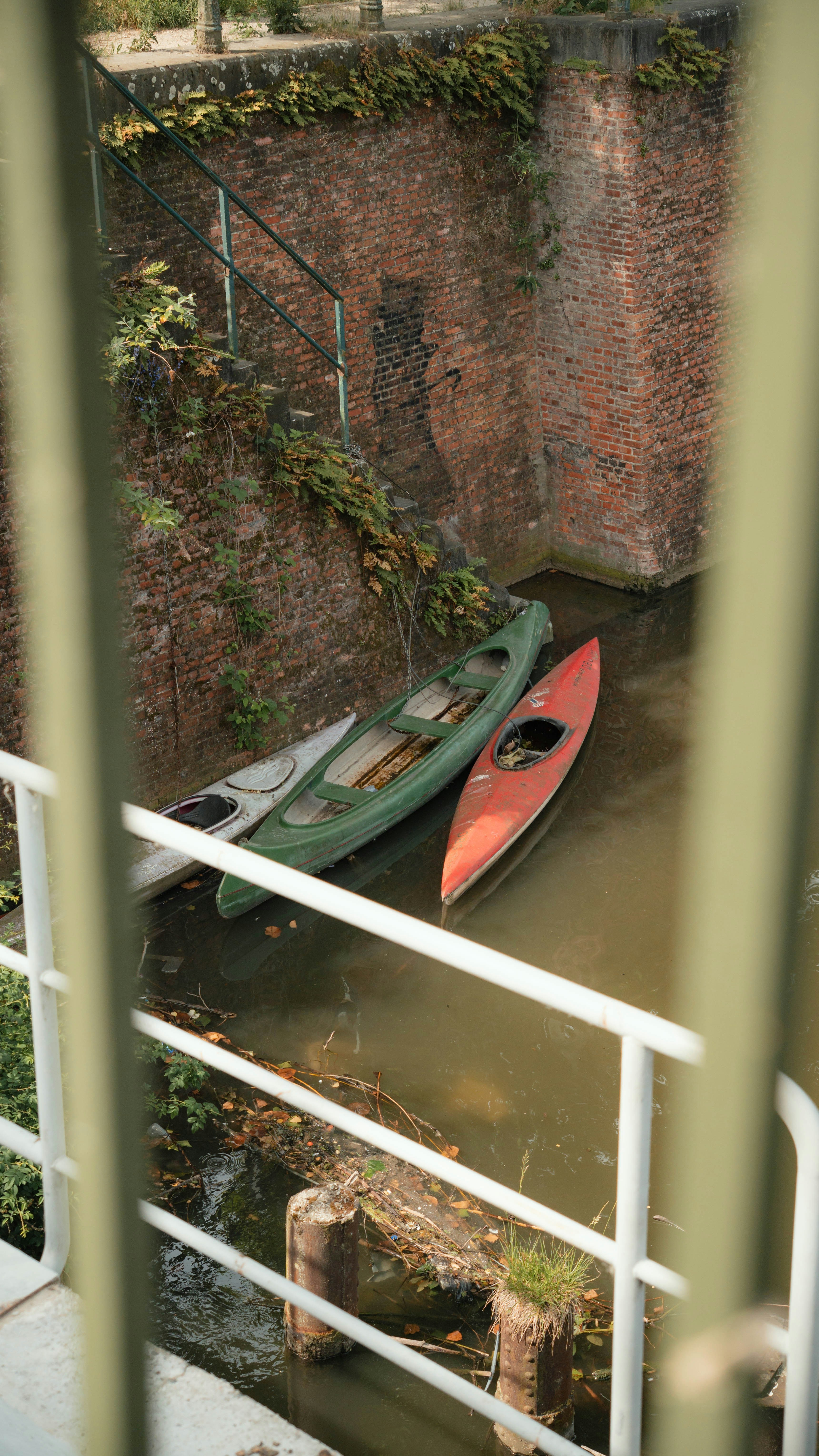 Rusty Channel: Two Boats Rest in a Narrow Brick Canal