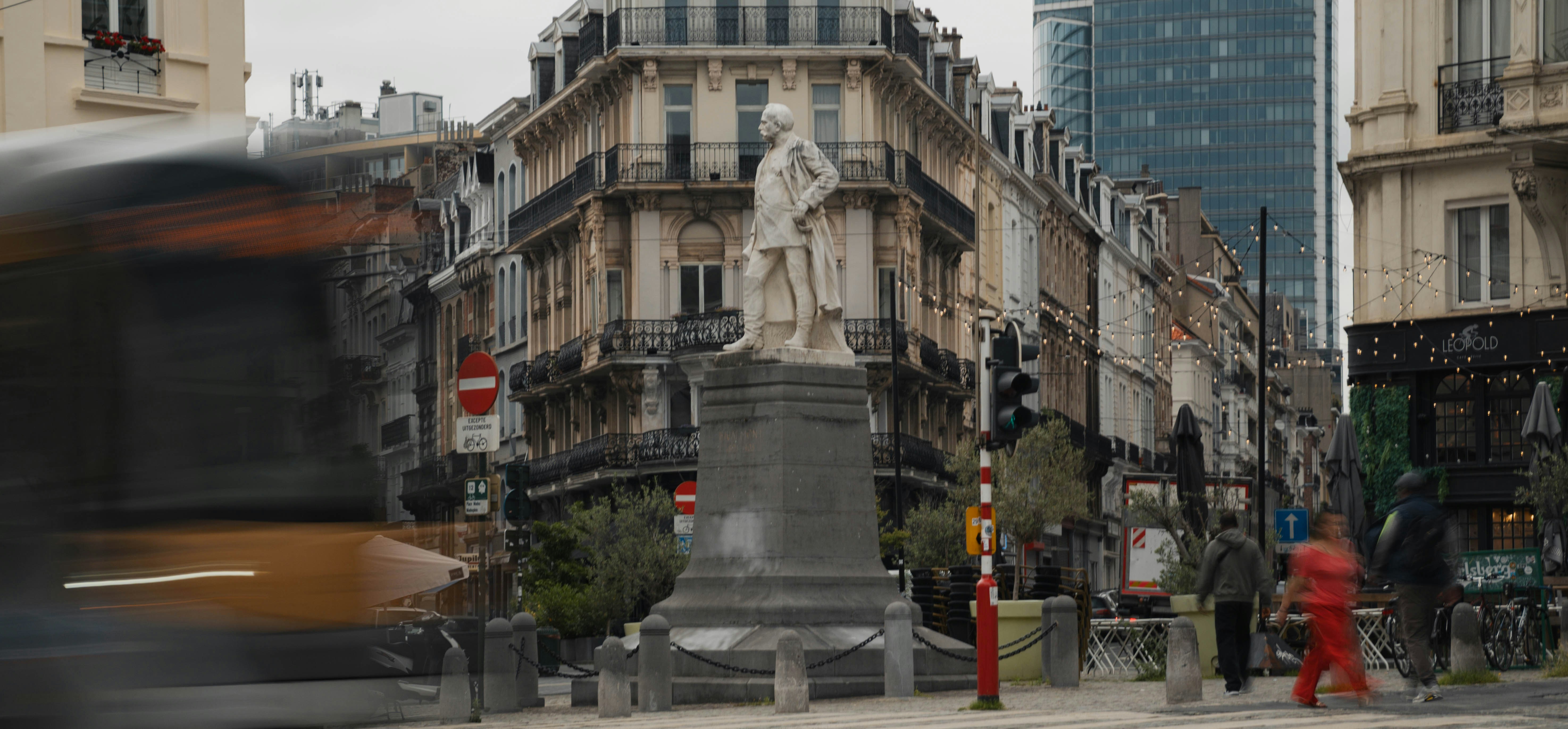 Statue Framed by Parisian Facades and Moving Street