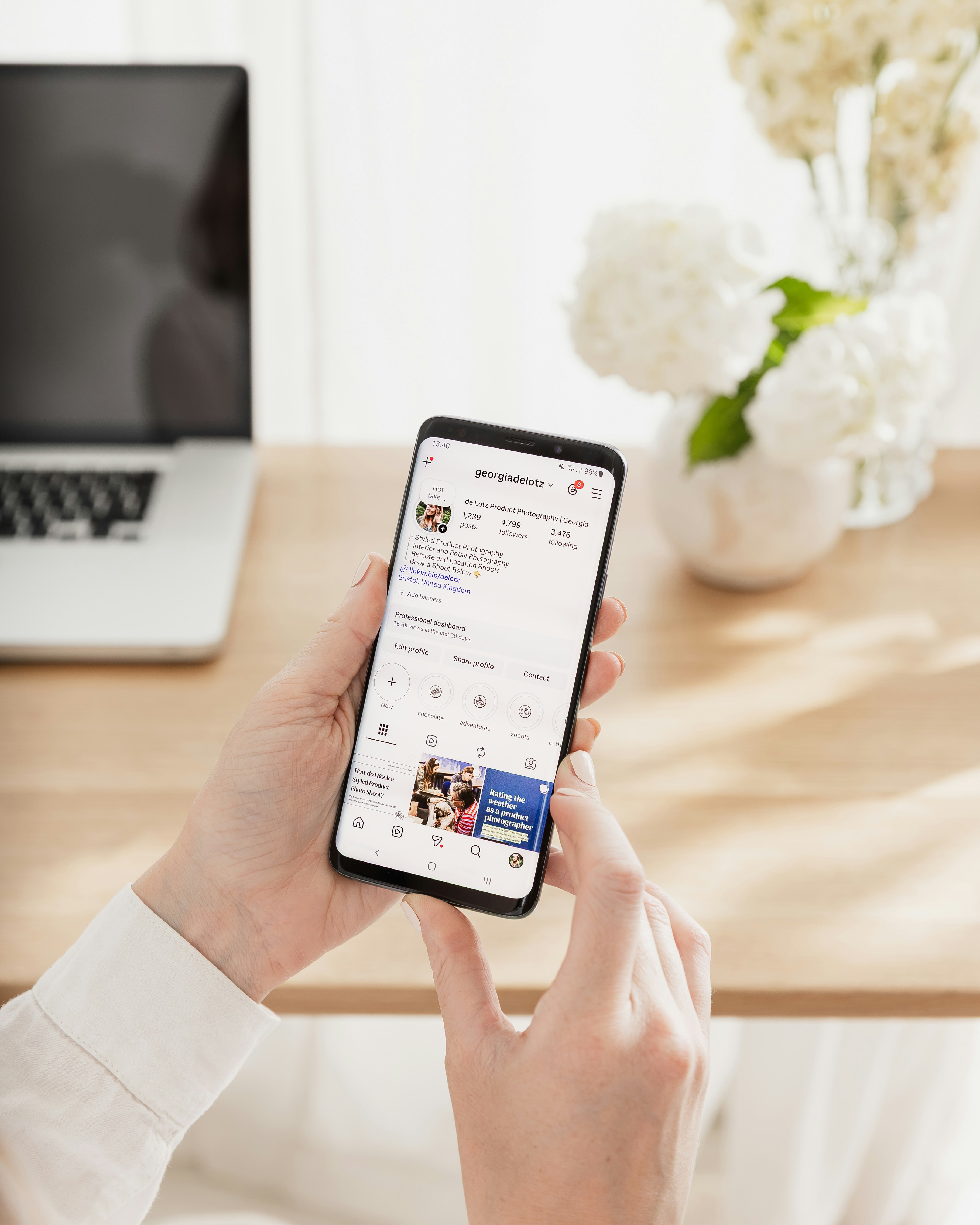 Between Screens: A Hands-on Pause with a smartphone in a bright, tidy workspace