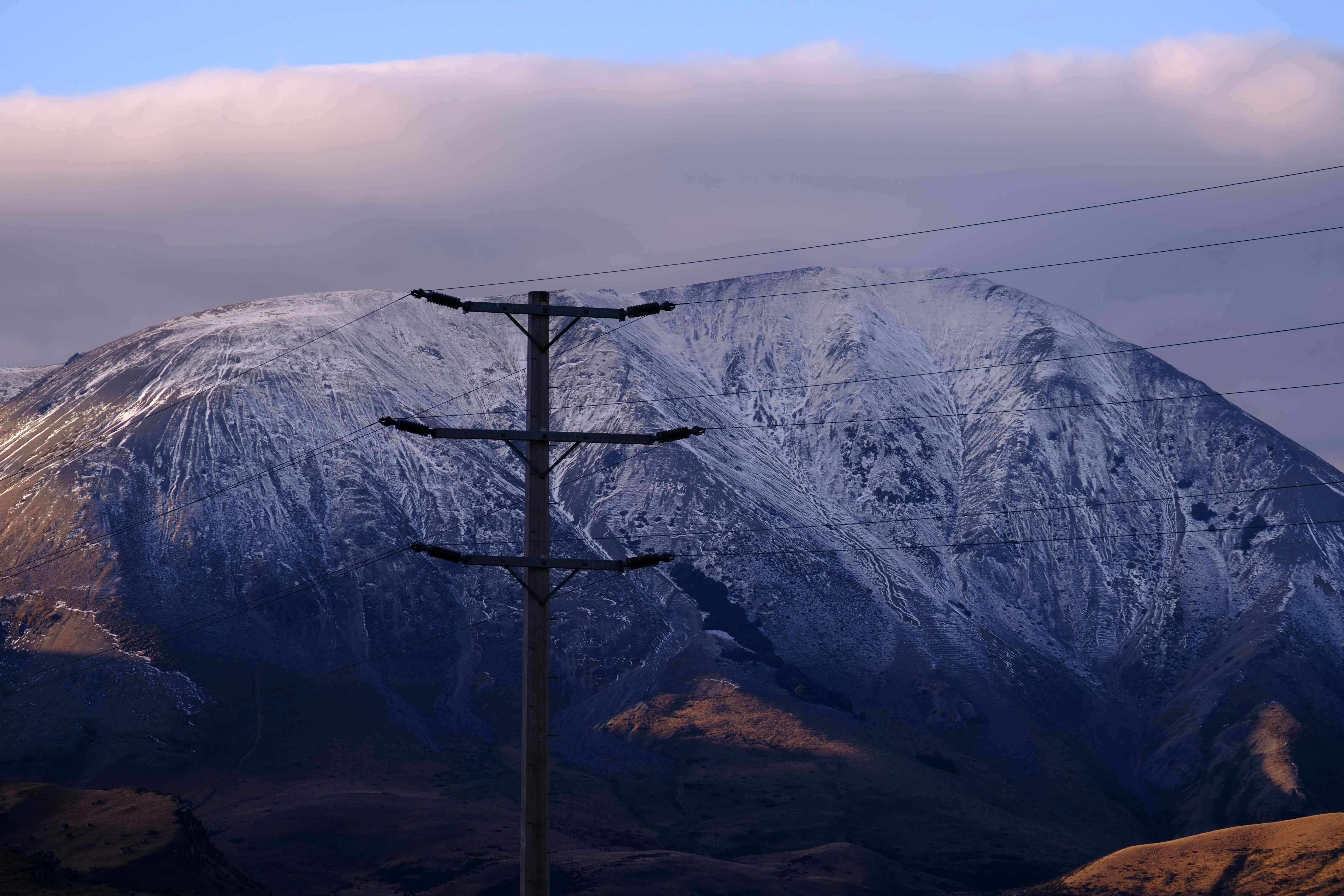 Snow-Capped Ridge Framed by a Silhouetted Power Line