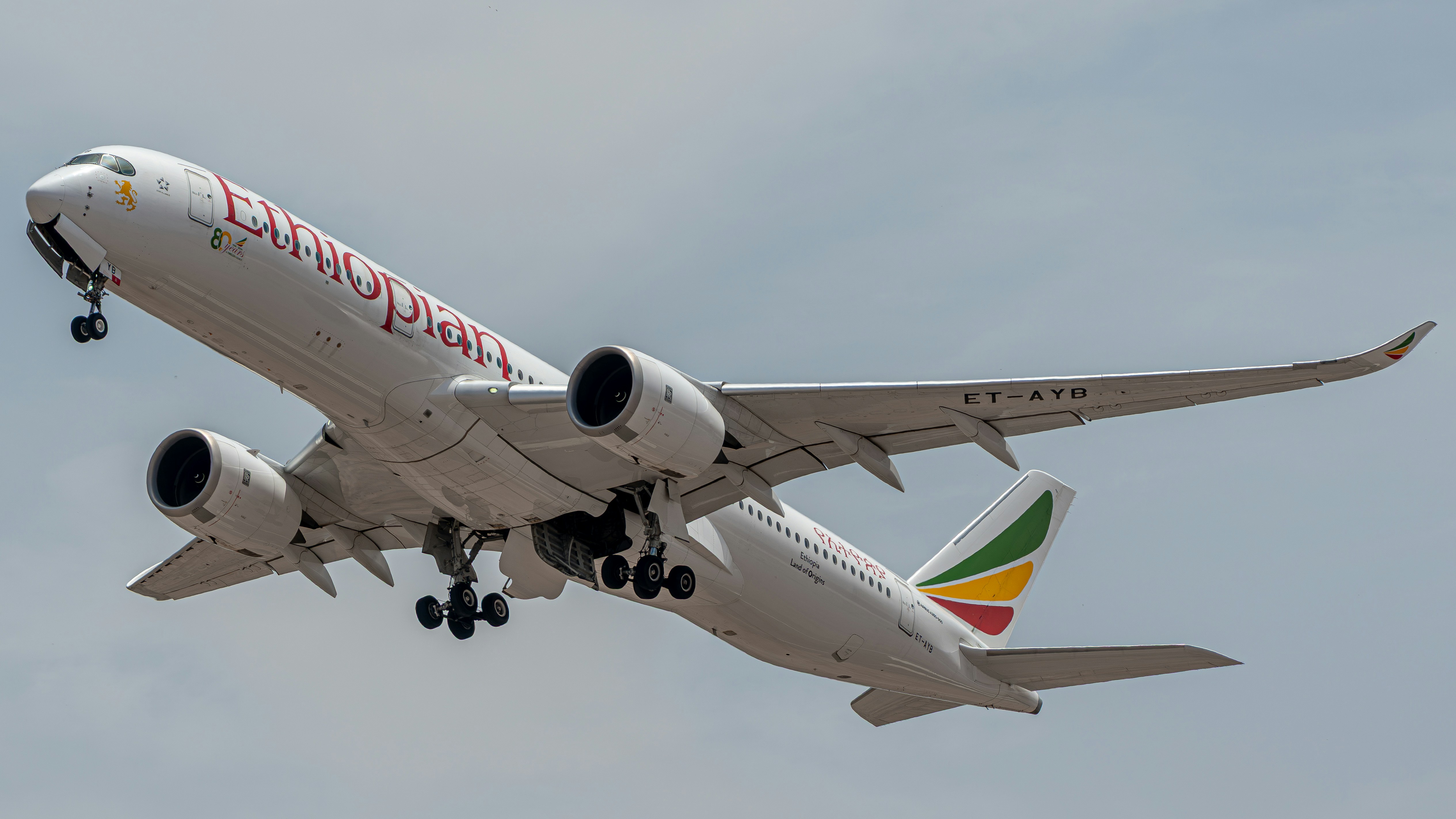 Wing-gleaned ascent: Ethiopian Airlines A350 in ascent against a pale sky