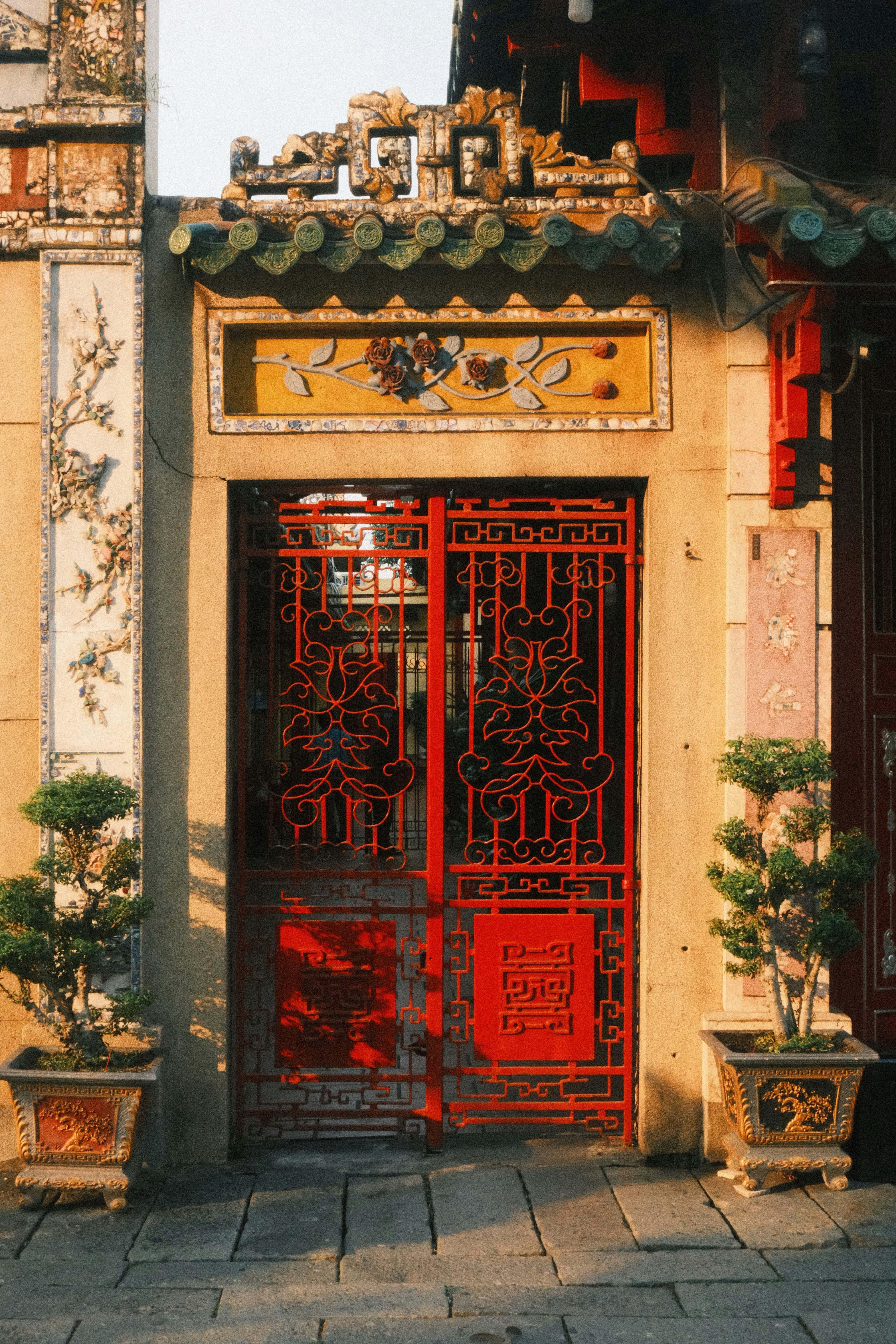 Scarlet Gates: An Ornate Chinese Door Framed by Ceremonial Gardens