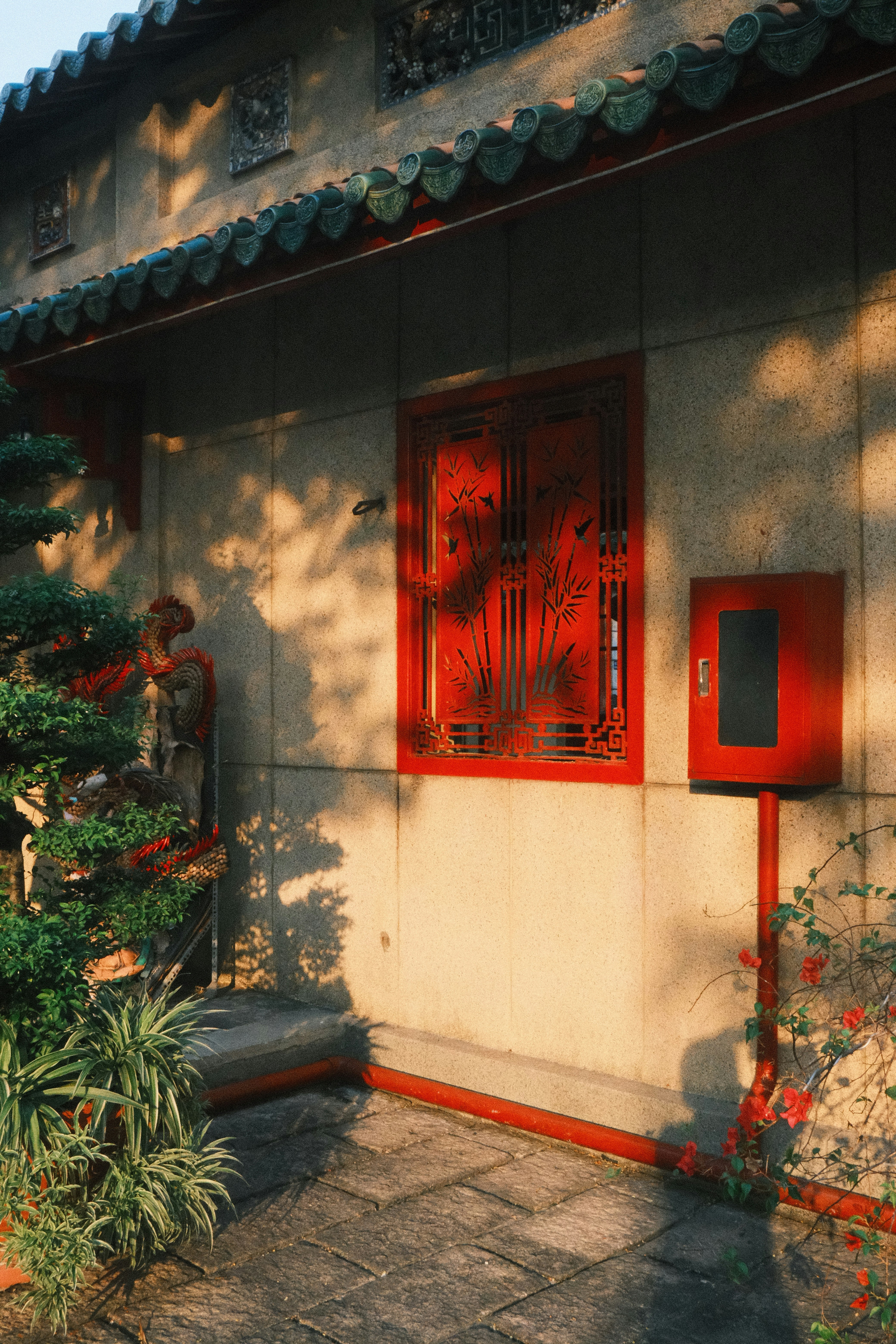 Red Gate, Quiet Courtyard: A Dappled Moment in Sunlit Stone