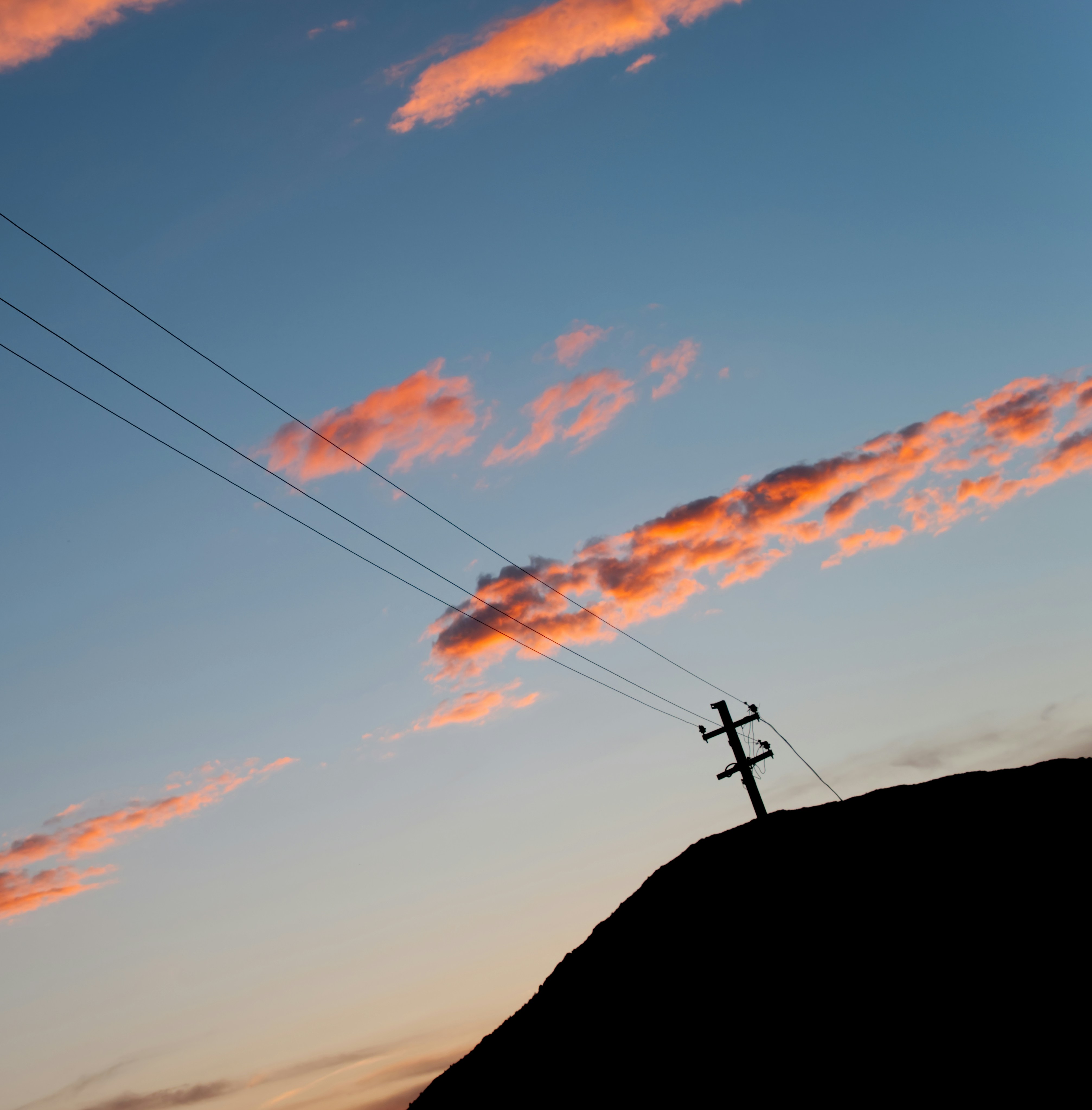 Rising Power Lines Against a Sunset Crest