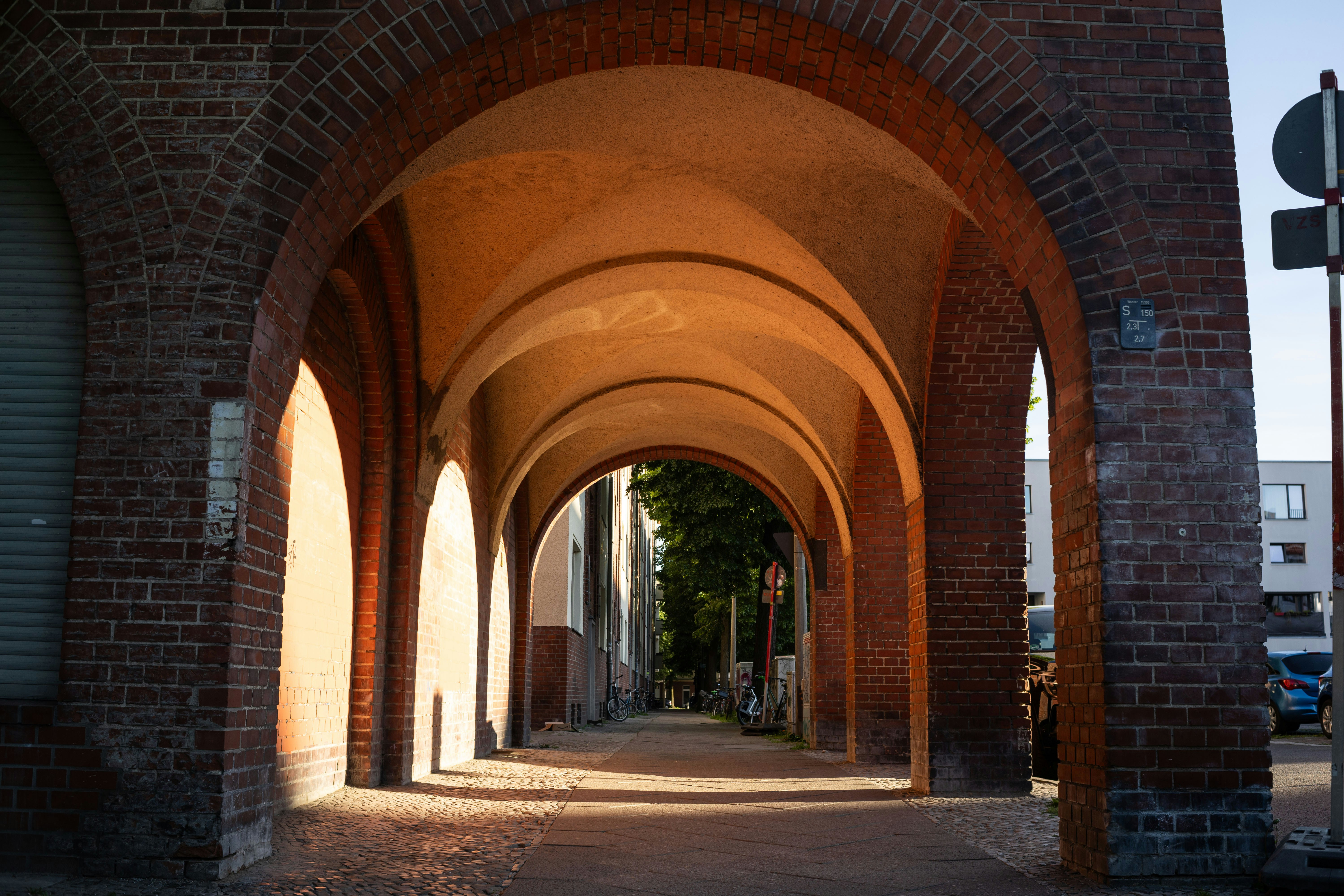 Golden Archway Corridor: A Sunlit Passage Through Brick Arches