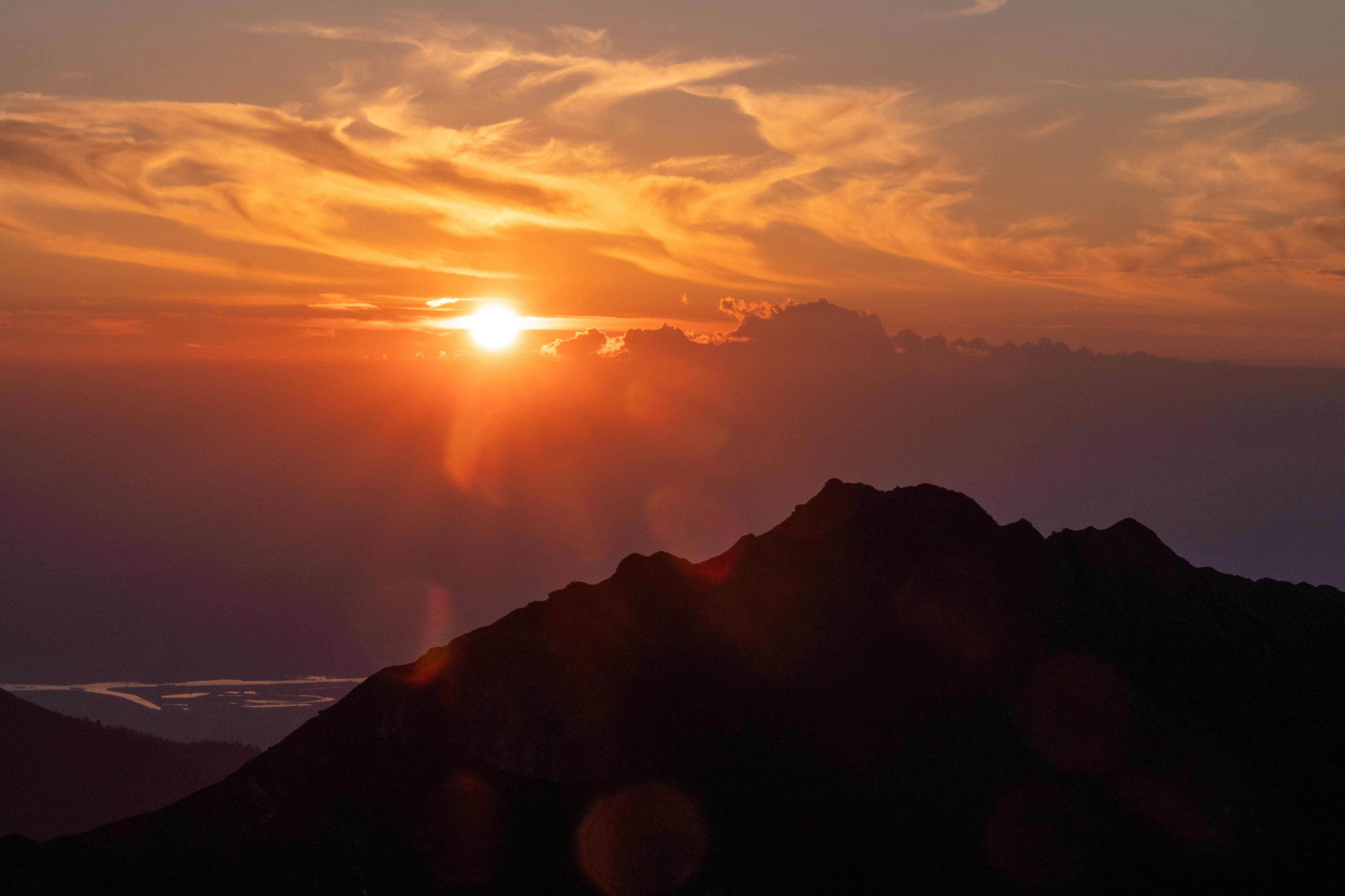 Sunlit Summit: Golden Hour Over a Silhouetted Crest