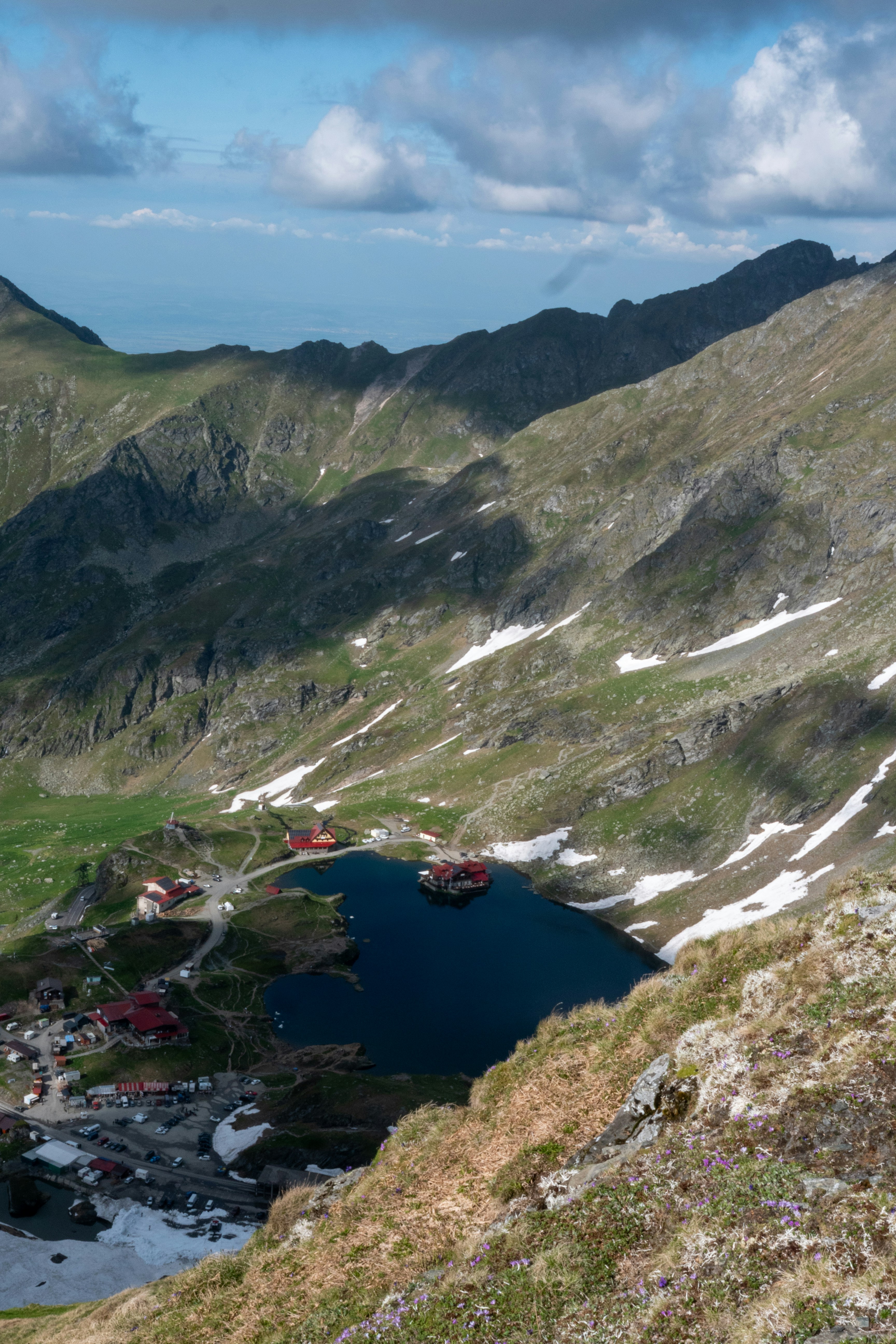 Alpine Lake Refuge: Red Roofs Nestled at the Edge of the Crags
