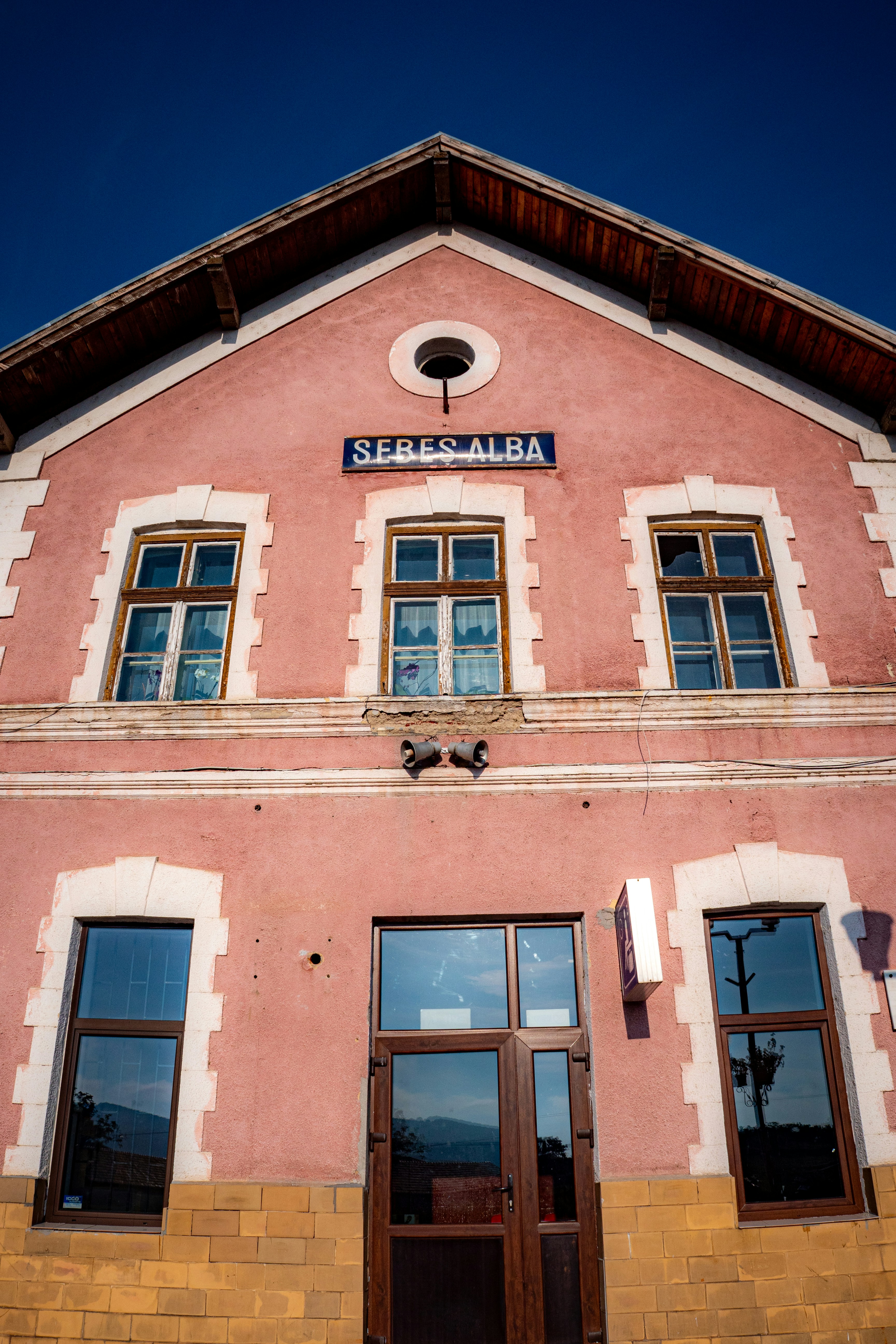 Sunlit Facade of Seaside Station: Peach Wall and Tall Windows