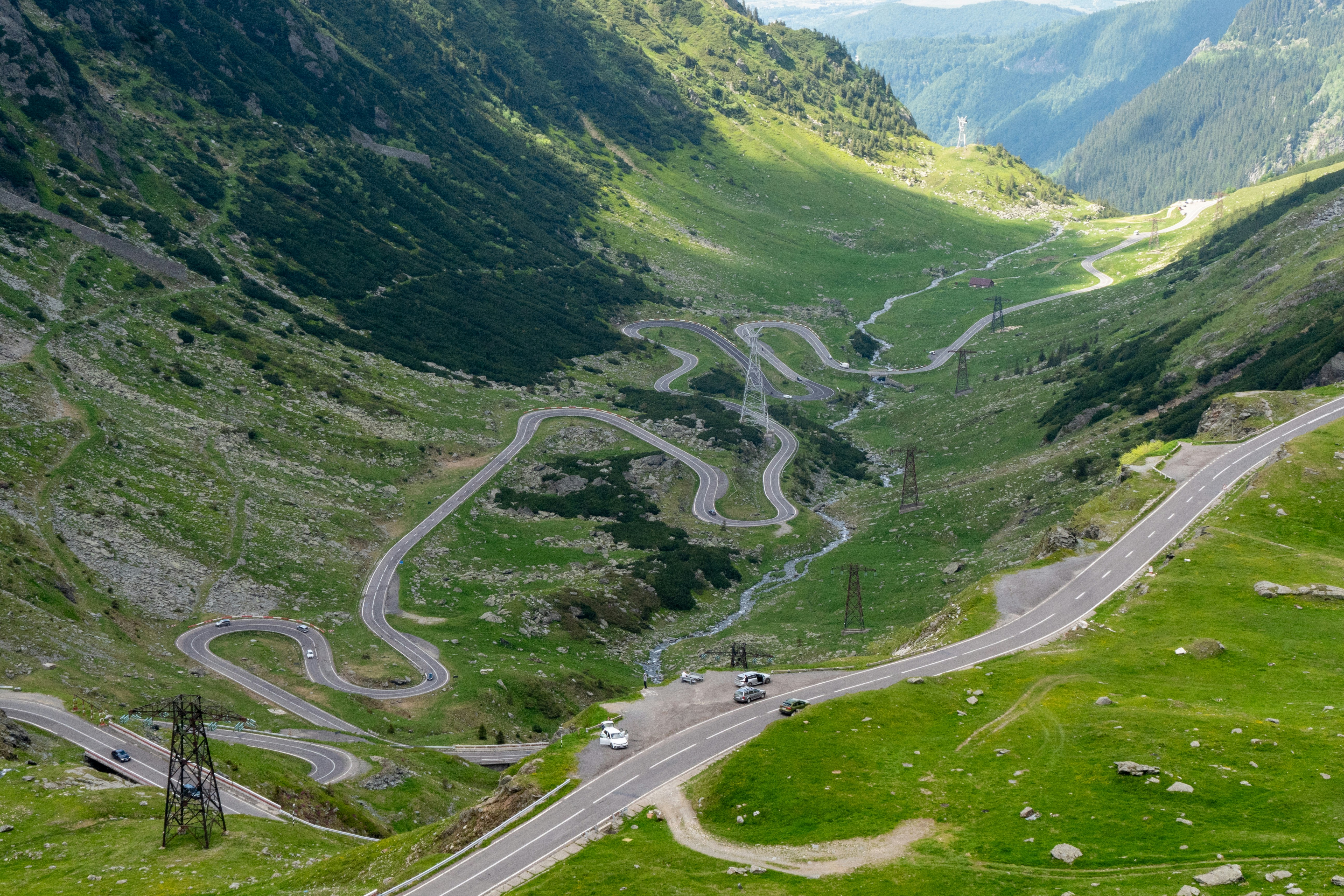 Serpentine Alpine Road through a Lush Green Valley
