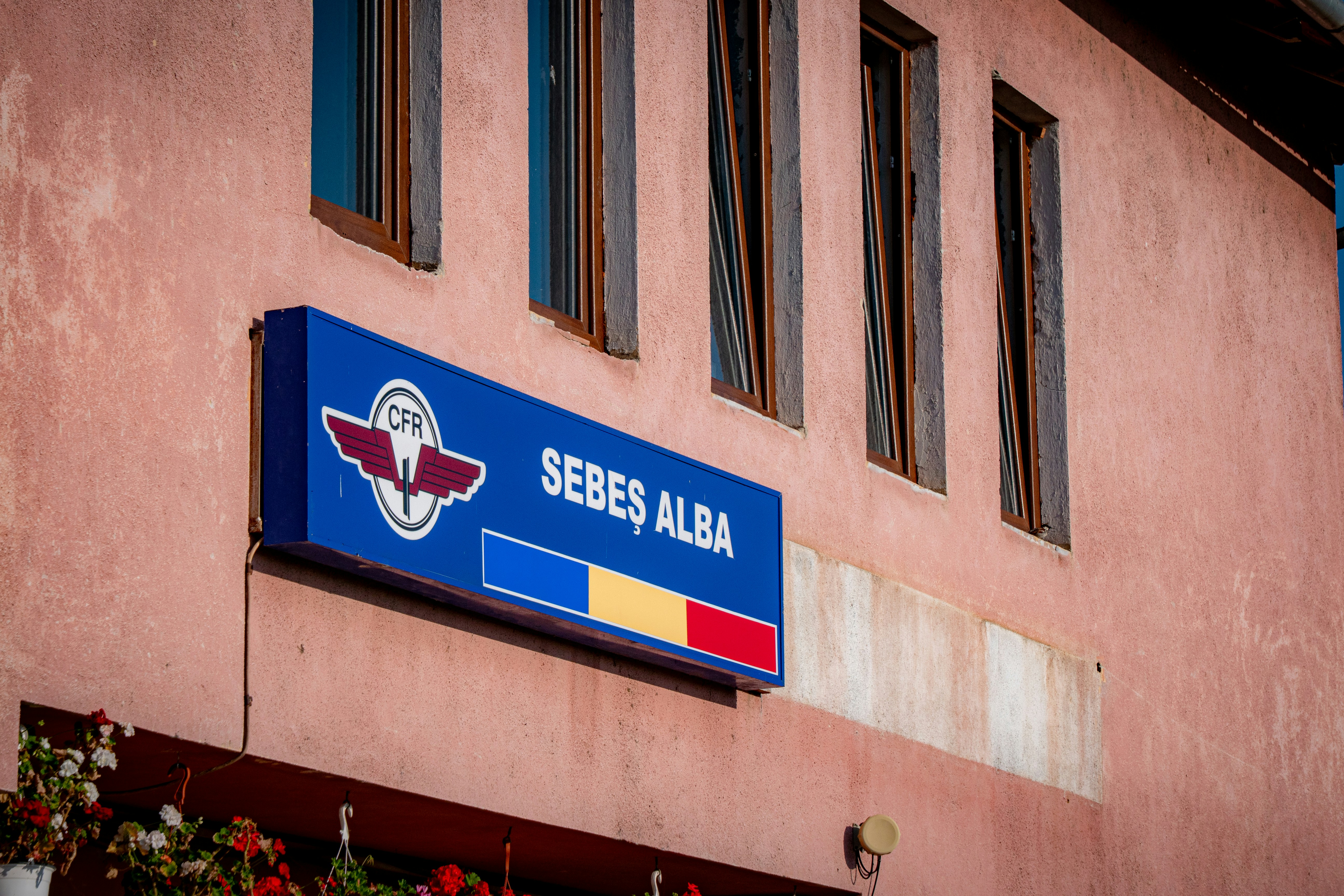 Signage on a pastel pink building under warm afternoon light