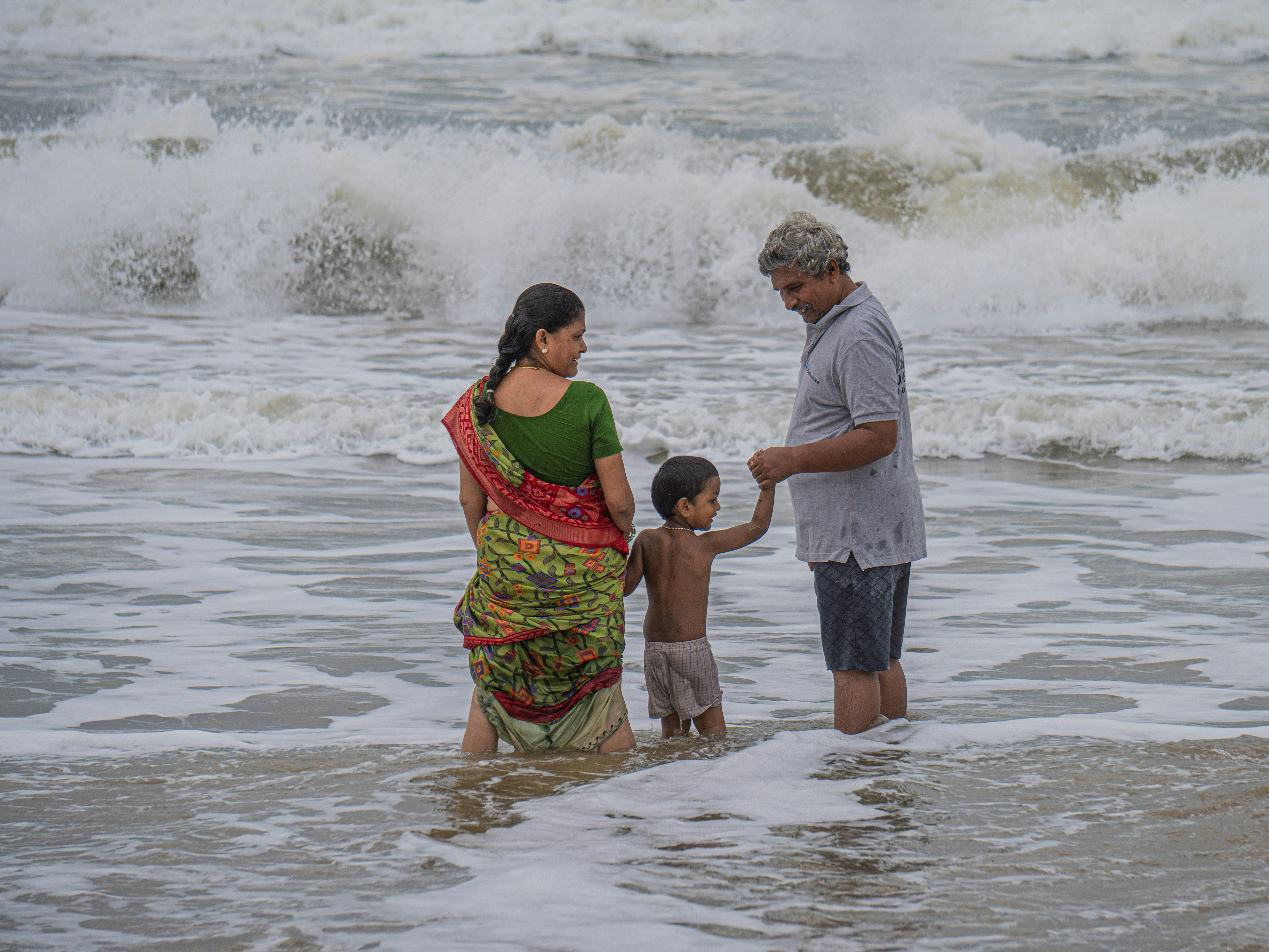 Family at the Tide: A Quiet Exchange by the Surf