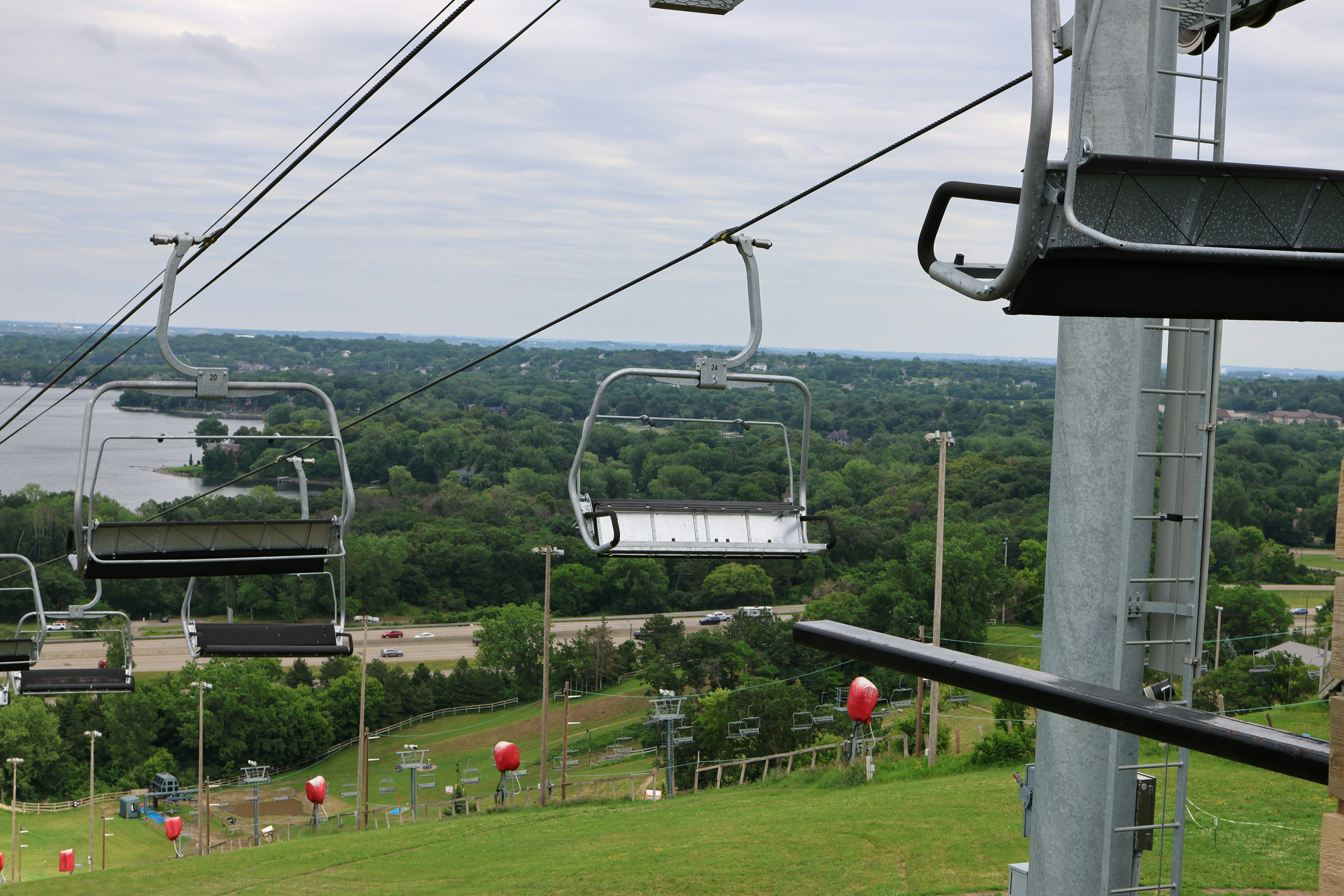 Lifted Silence: Chairs in Flight Over a Green Valley