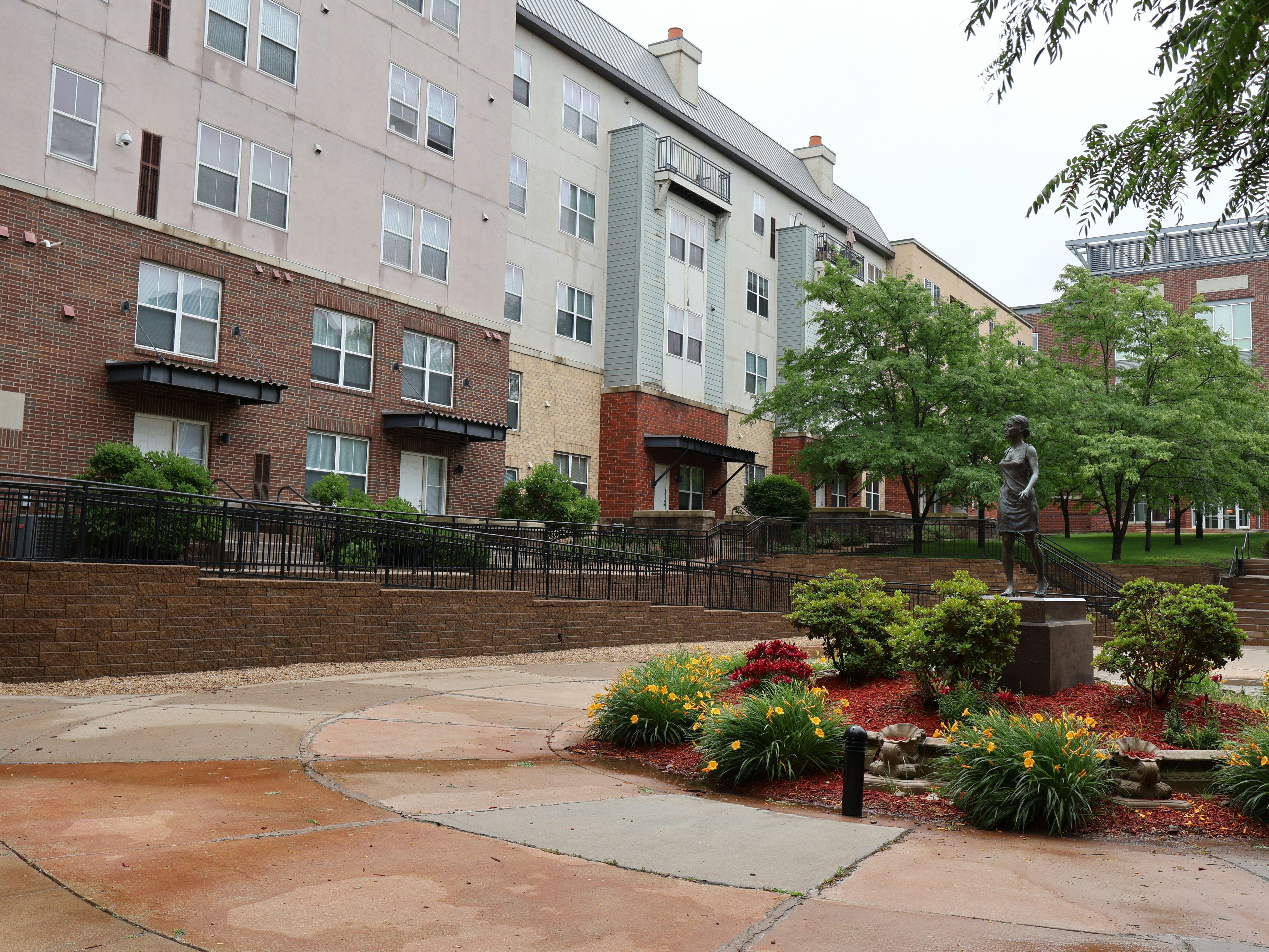 Statue and plaza garden framed by dormitory buildings