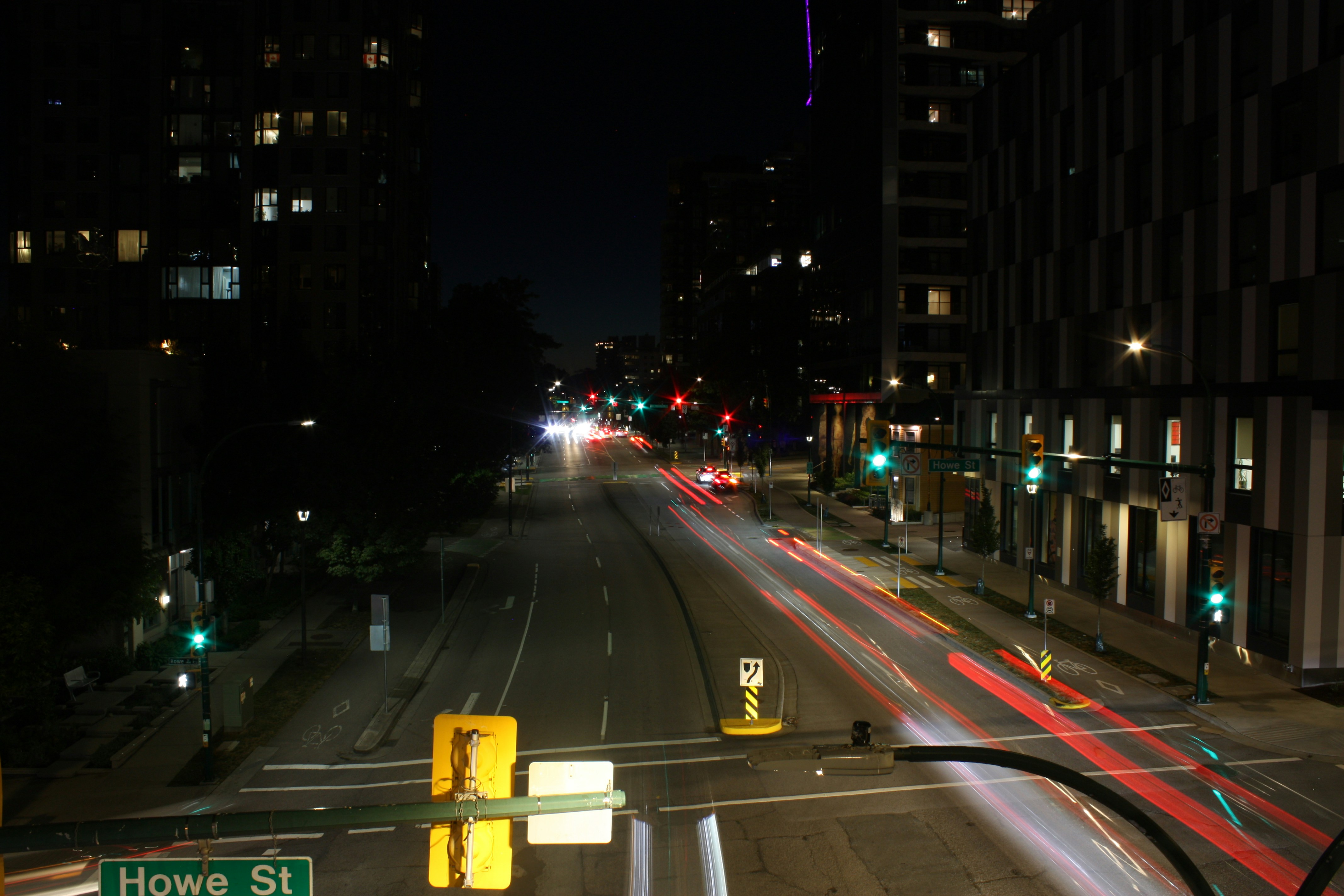 Night Urban Artery: Light Trails Across a Quiet Downtown Intersection