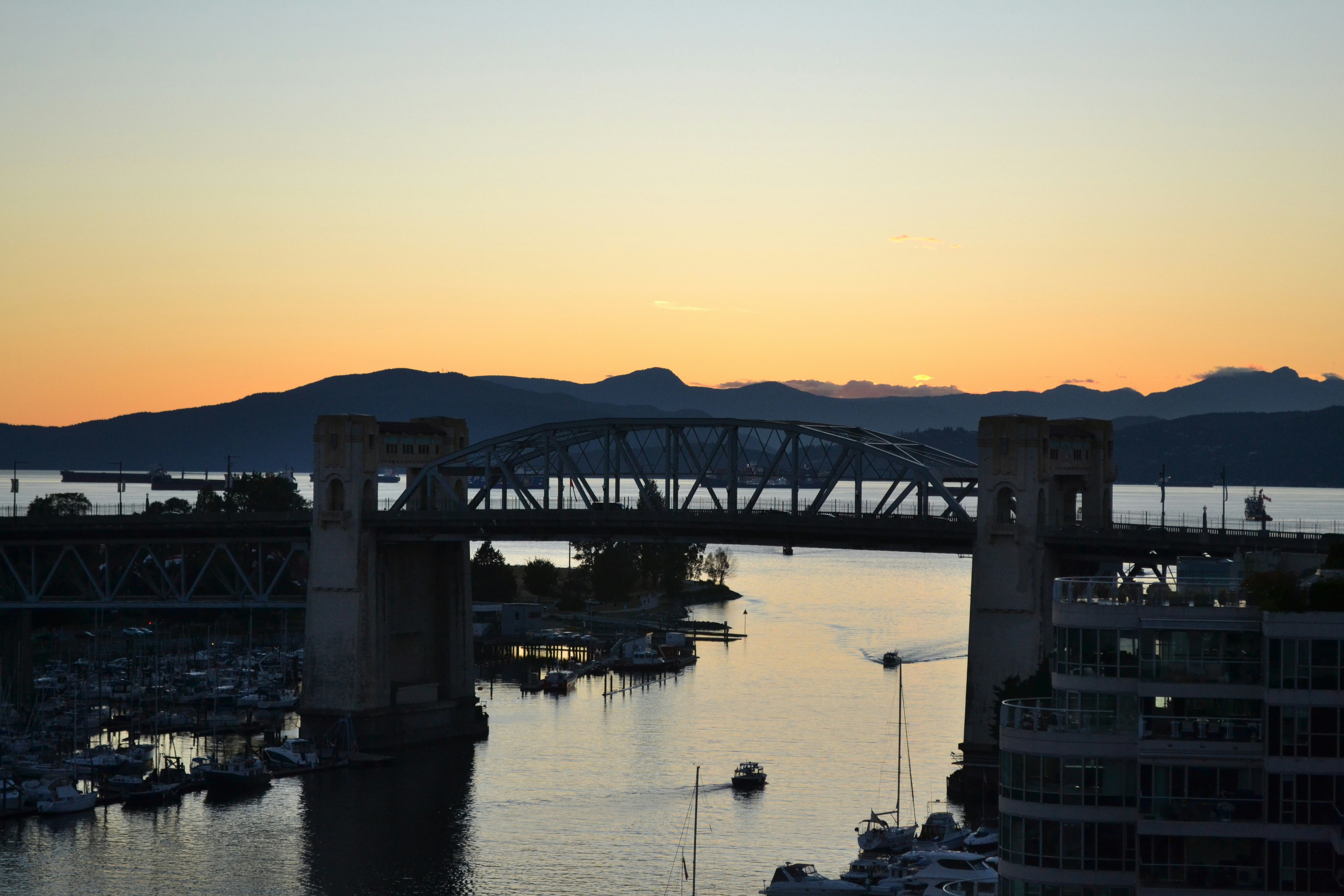 Sunset over the Harbor Bridge: silhouettes, water and distant hills