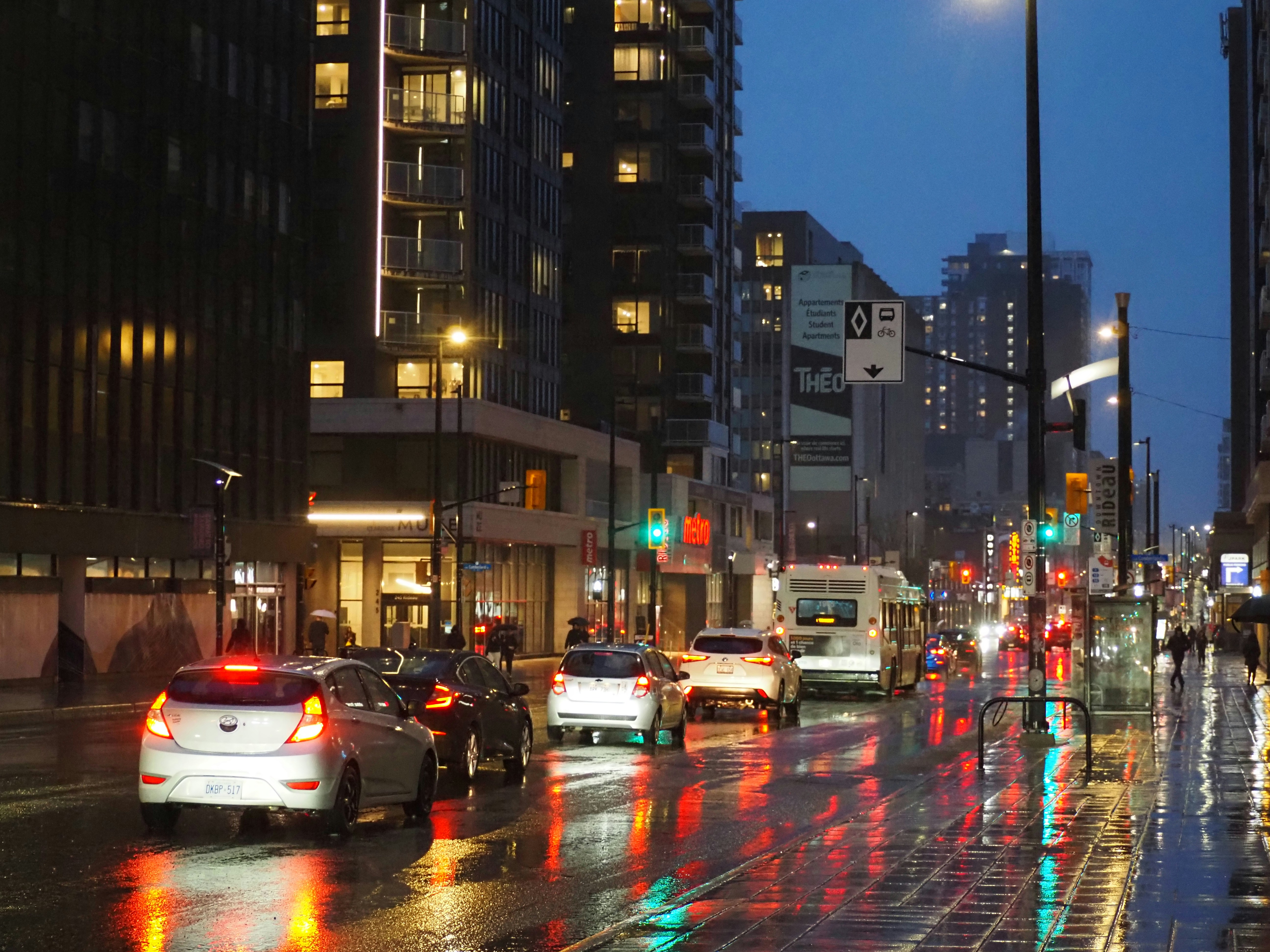 Neon Reflections: Evening Traffic on a Rain-Slick City Street