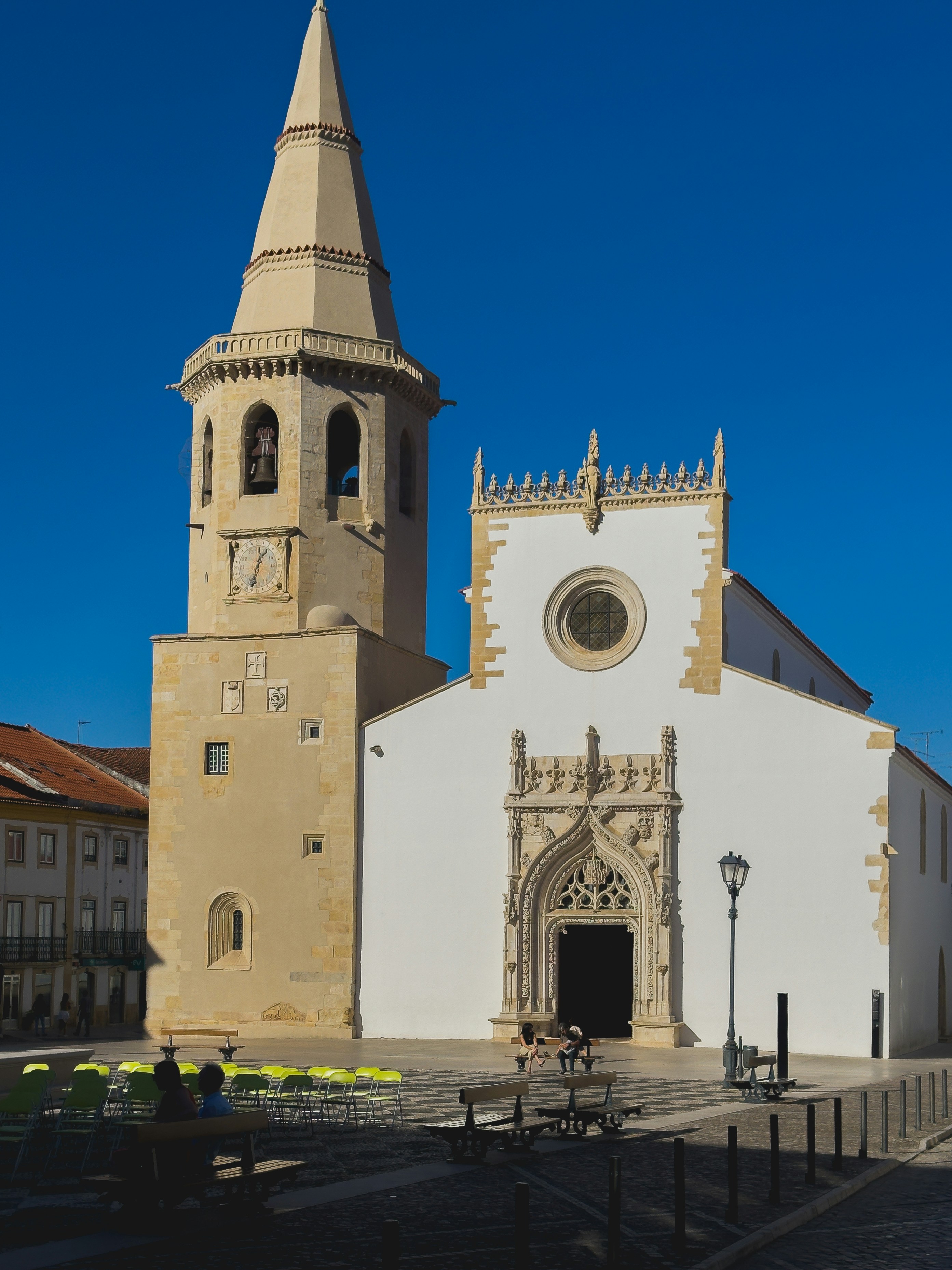 Sunlit Facade of a Historic Church with Bell Tower under a Clear Blue Sky